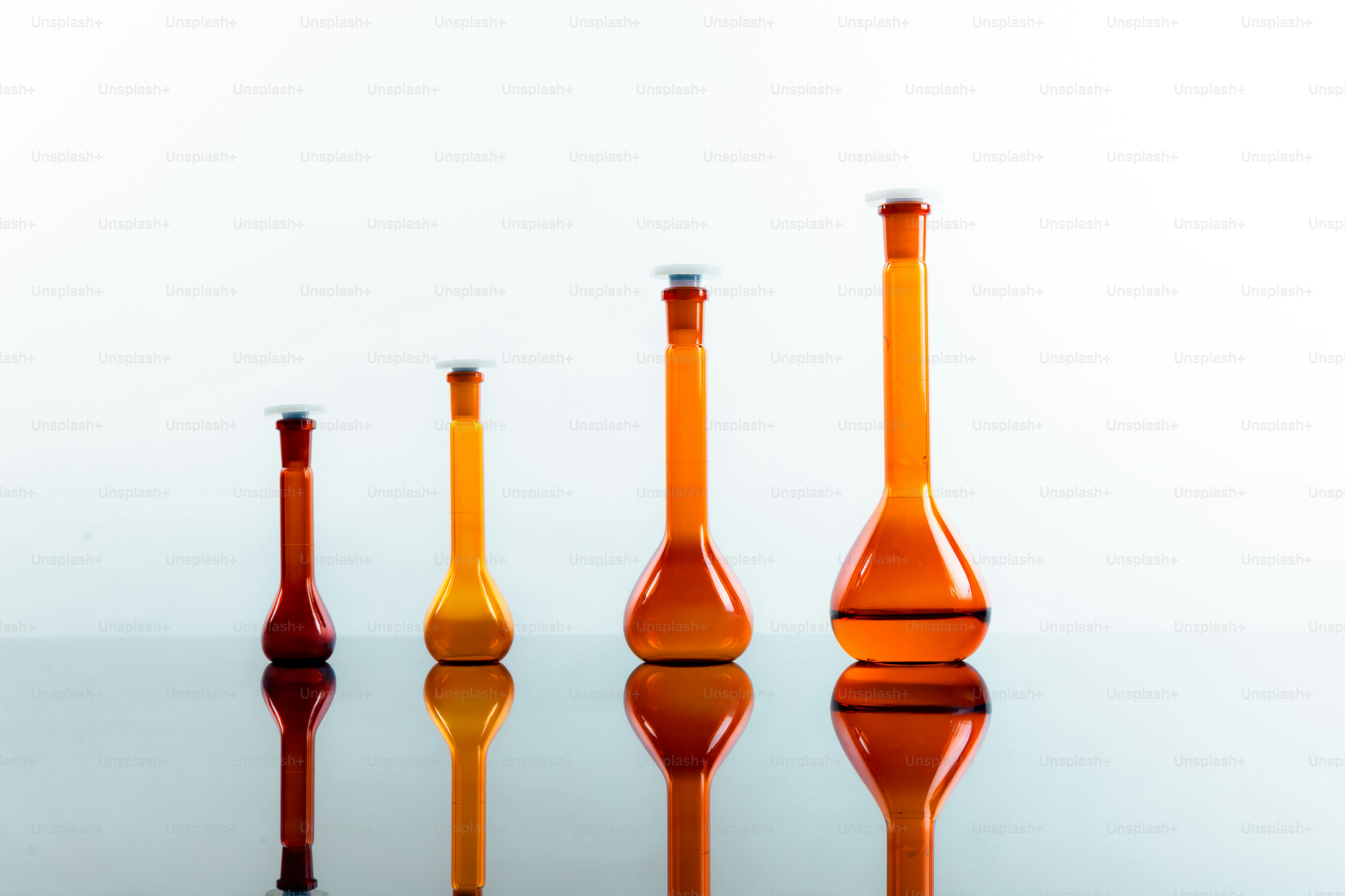 Four amber glass flasks of varying sizes photo – Science Image on Unsplash