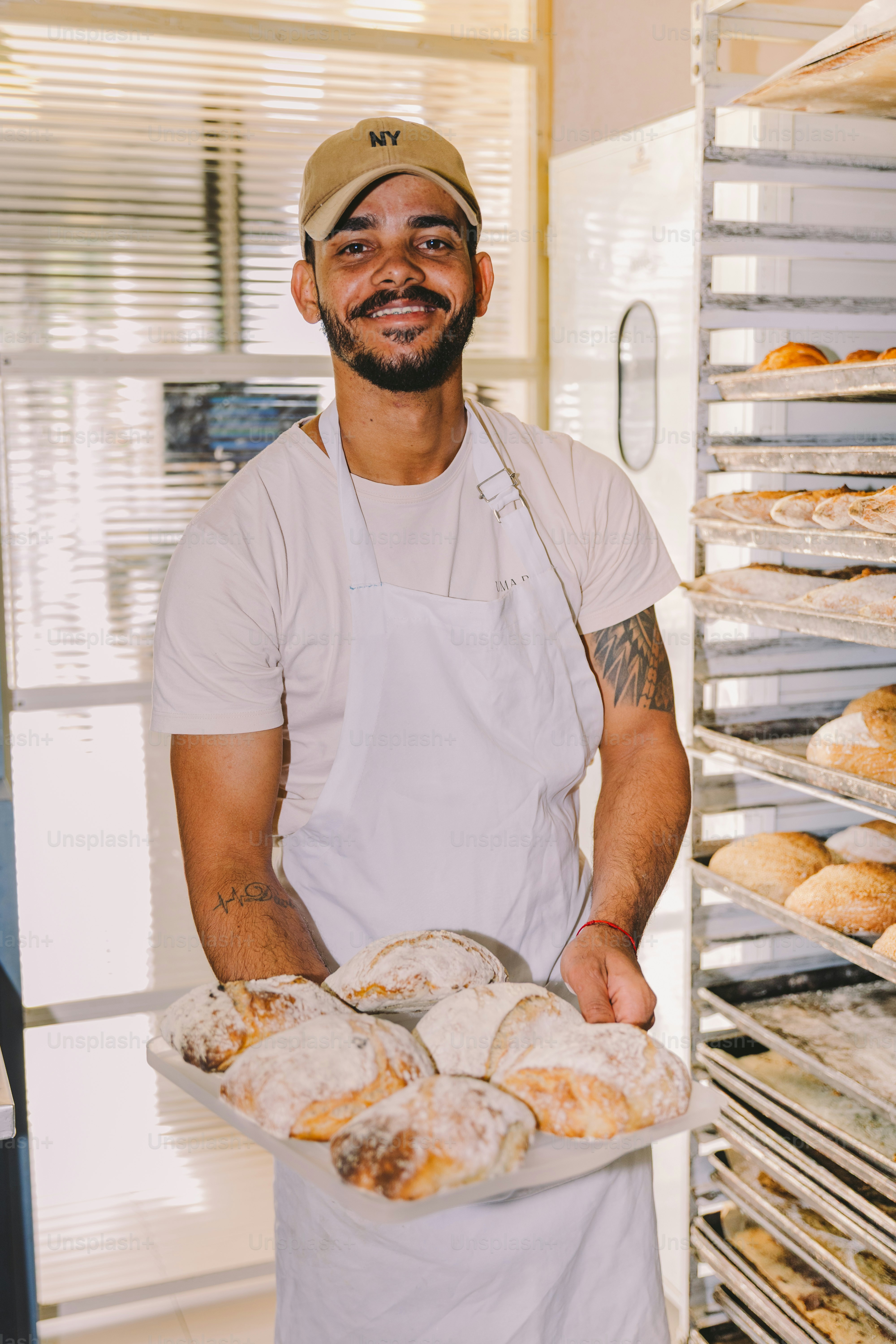 Baker holding two loaves of freshly baked sourdough bread. photo ...