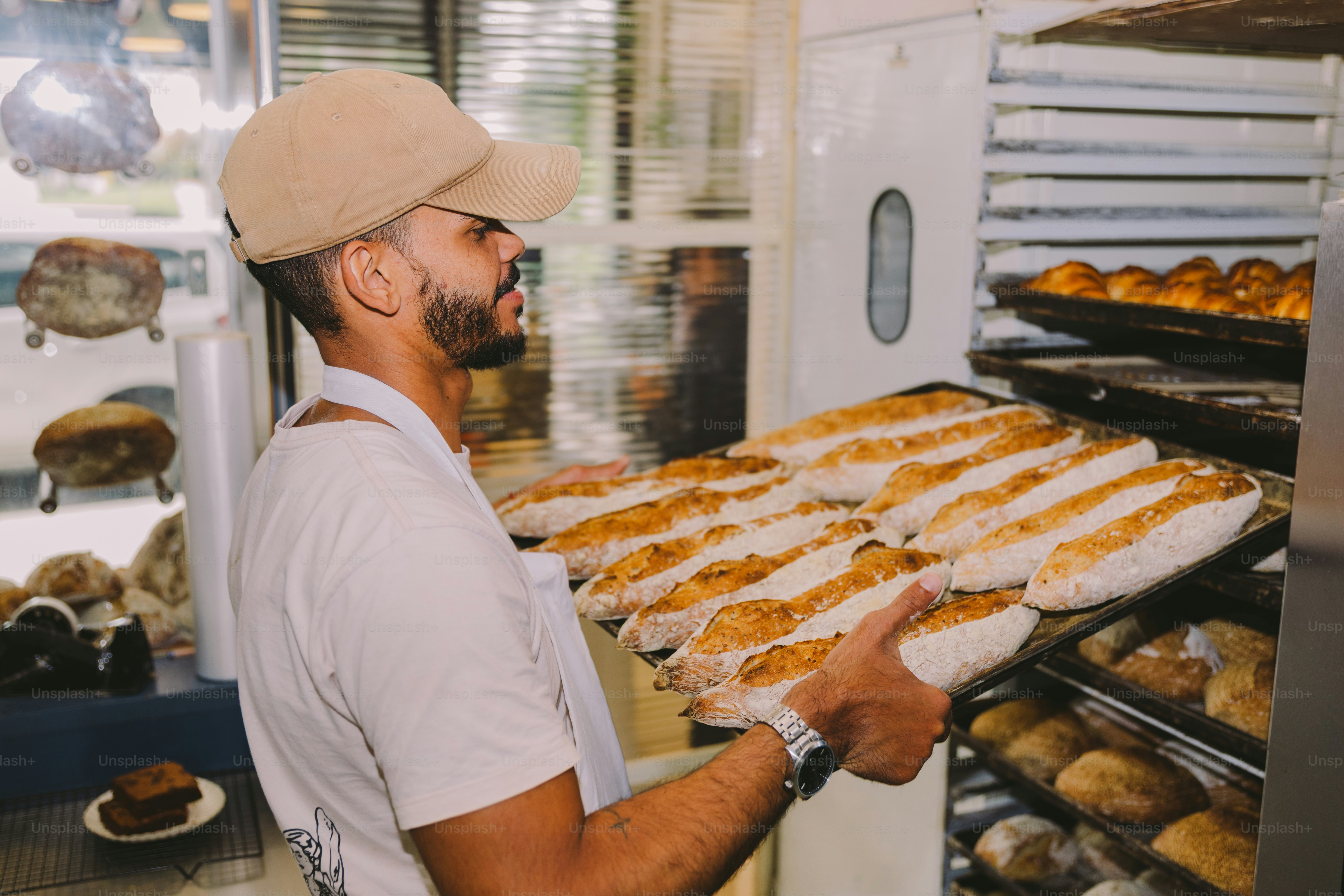 Baker holding two loaves of freshly baked sourdough bread. photo ...