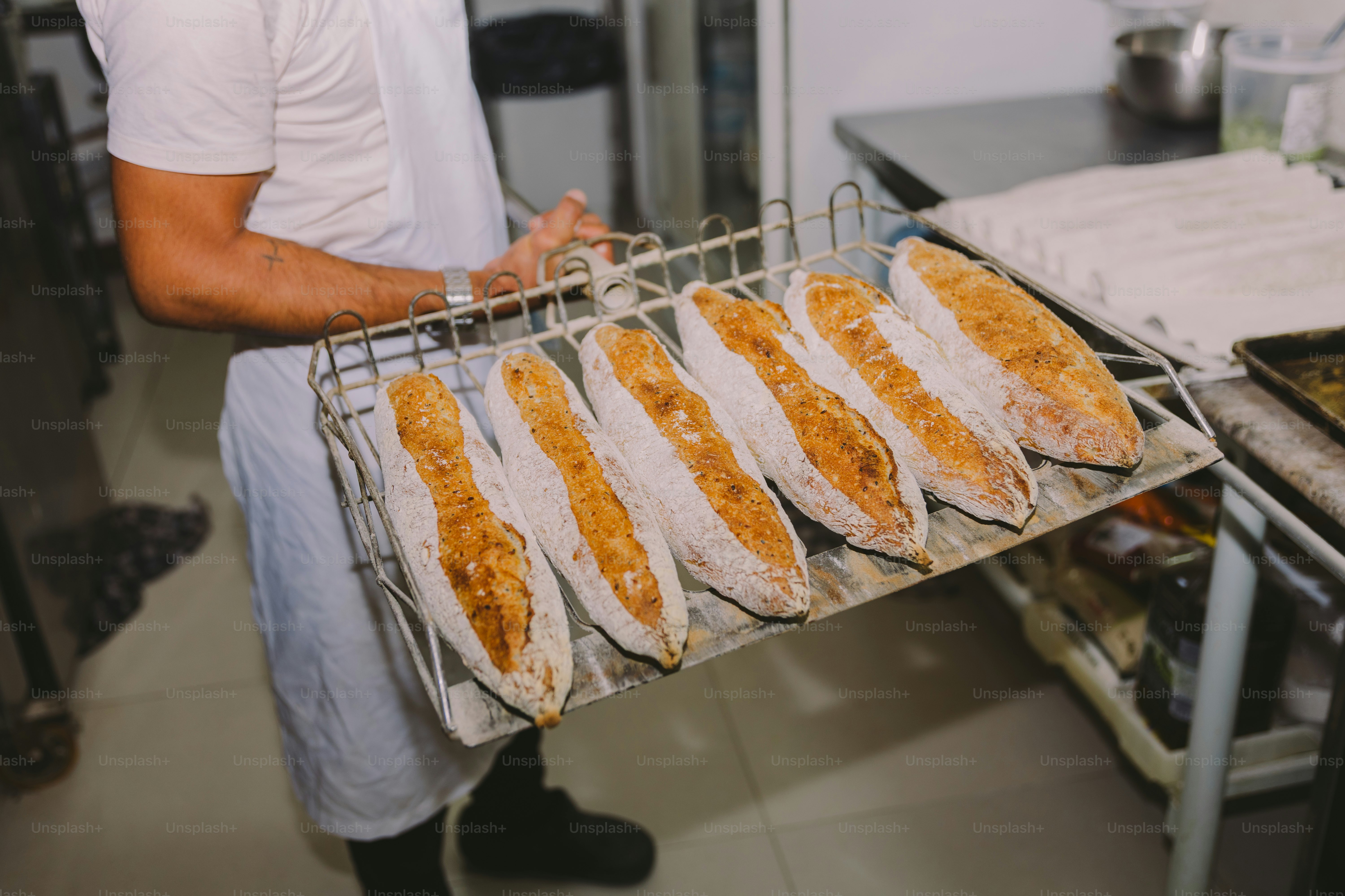 Baker holding two loaves of freshly baked sourdough bread. photo ...