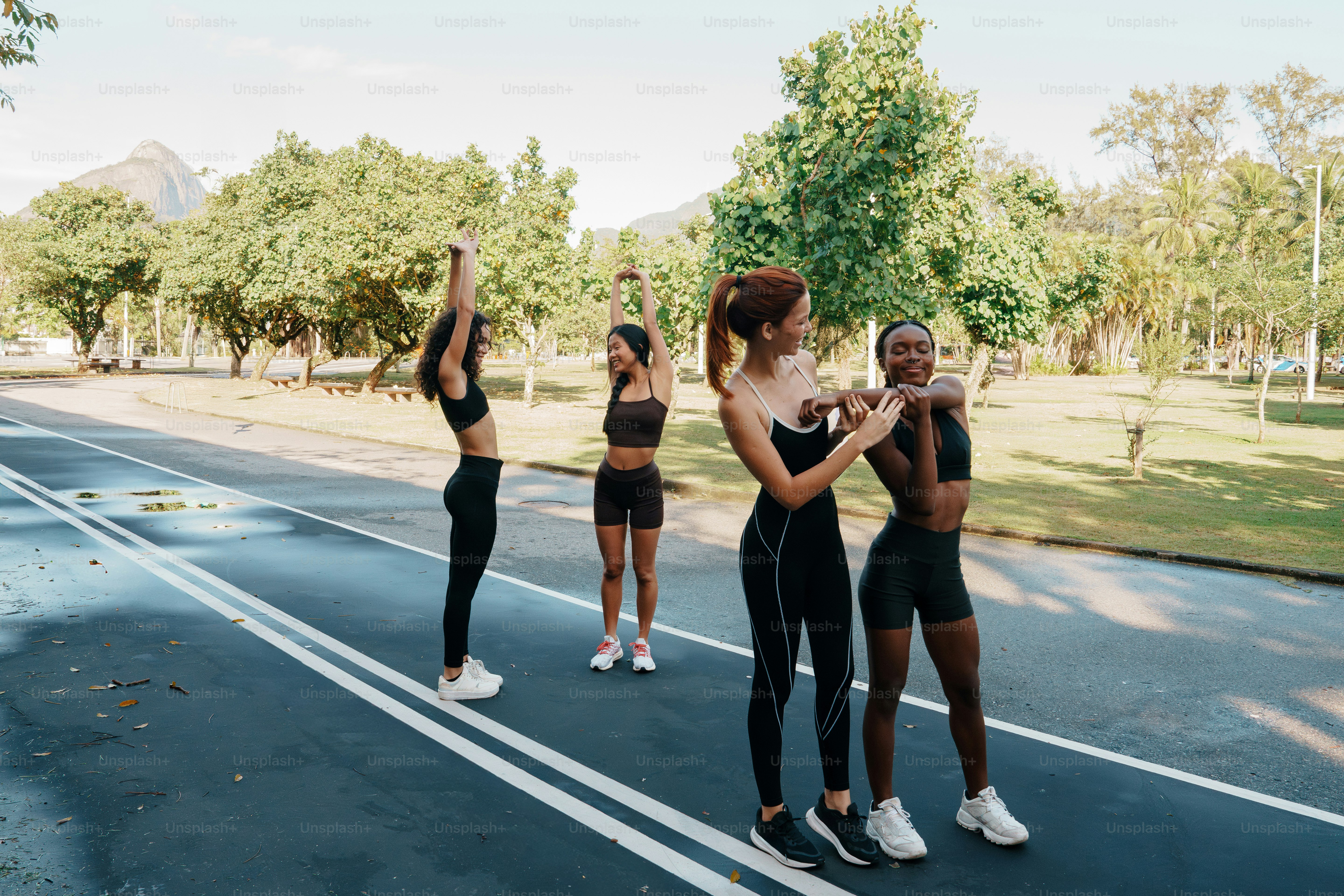 Four friends laughing while sitting on a bench outdoors. photo ...
