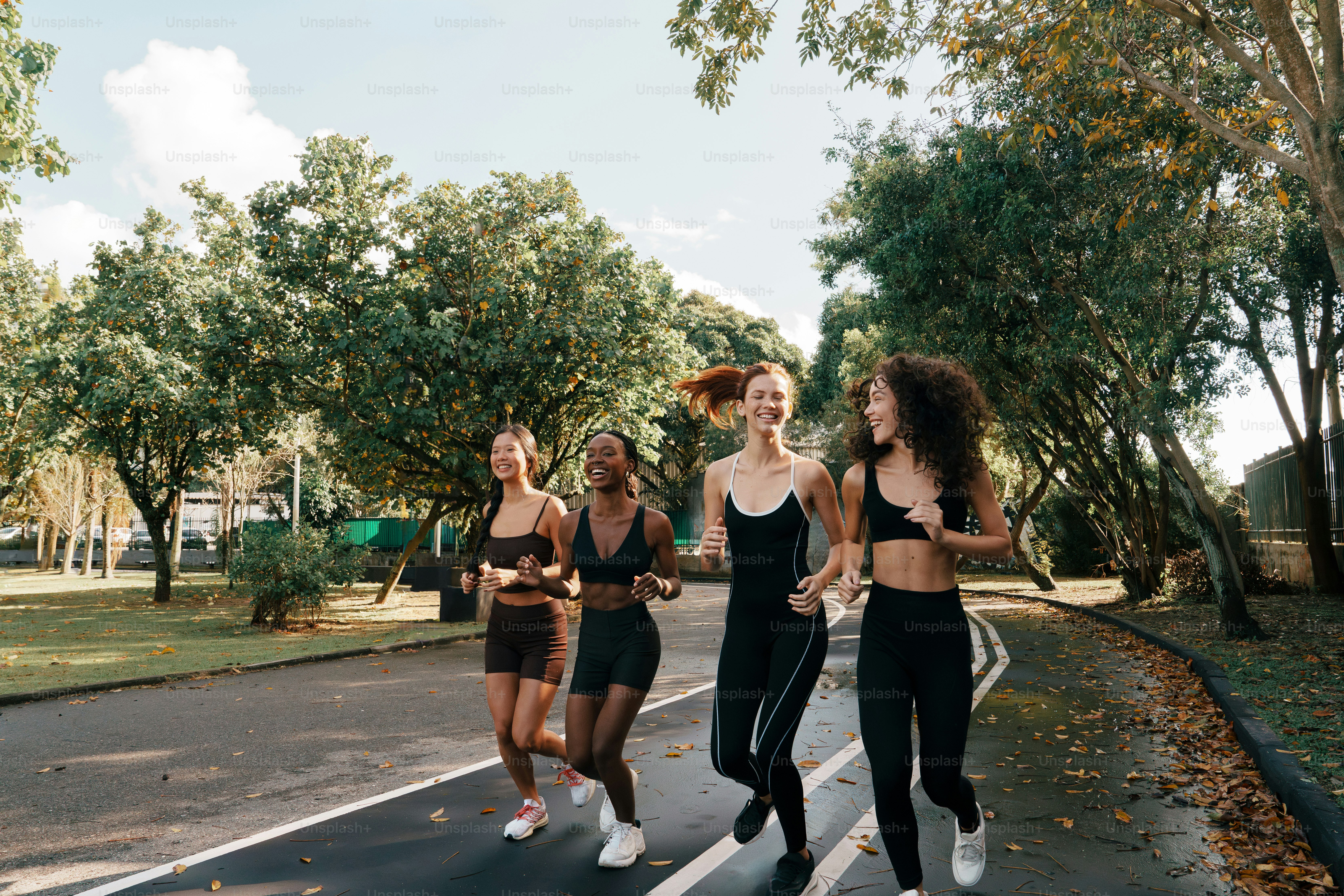 Four friends laughing while sitting on a bench outdoors. photo ...