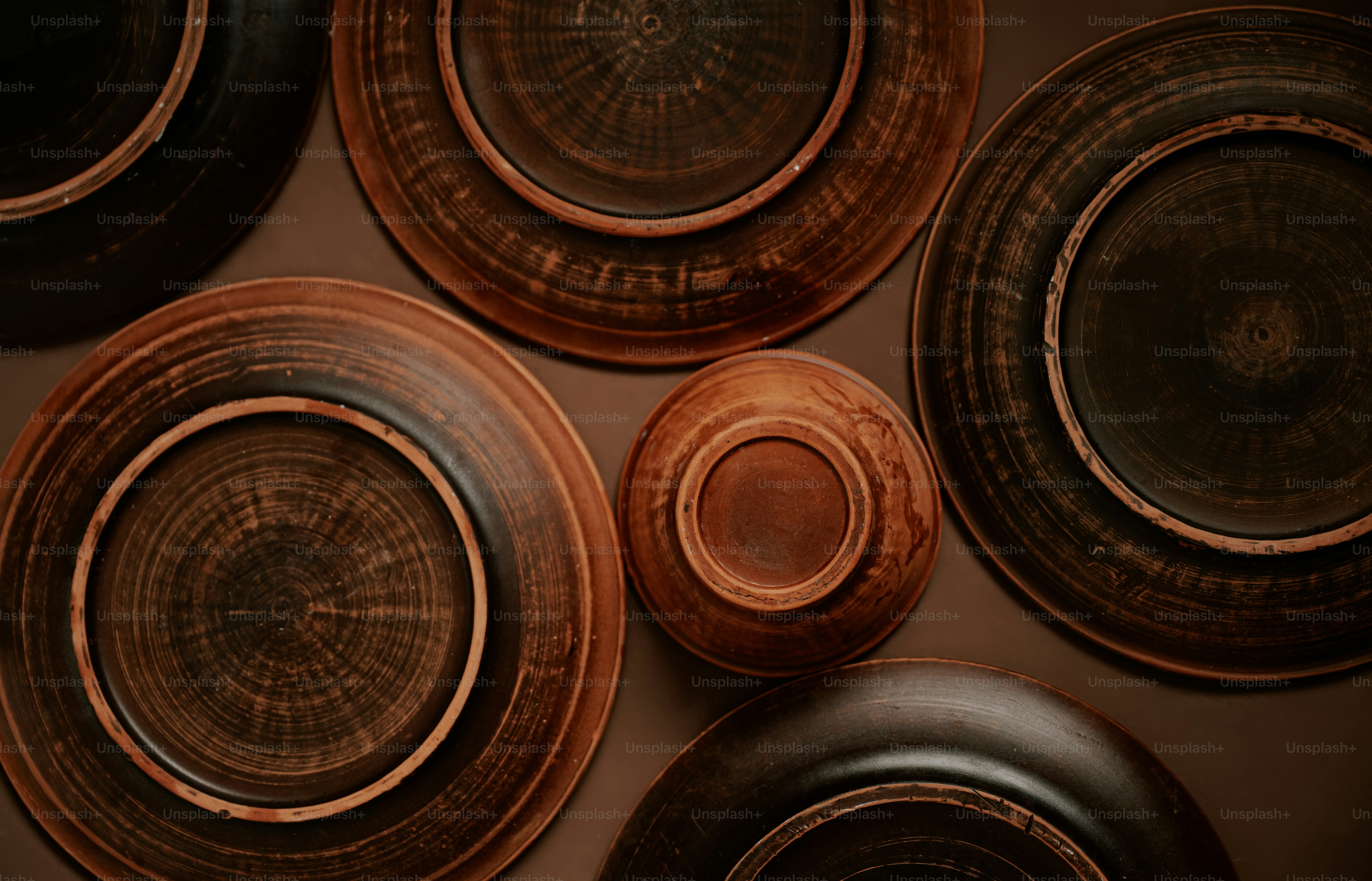 Several rustic ceramic plates and bowls arranged together. photo ...