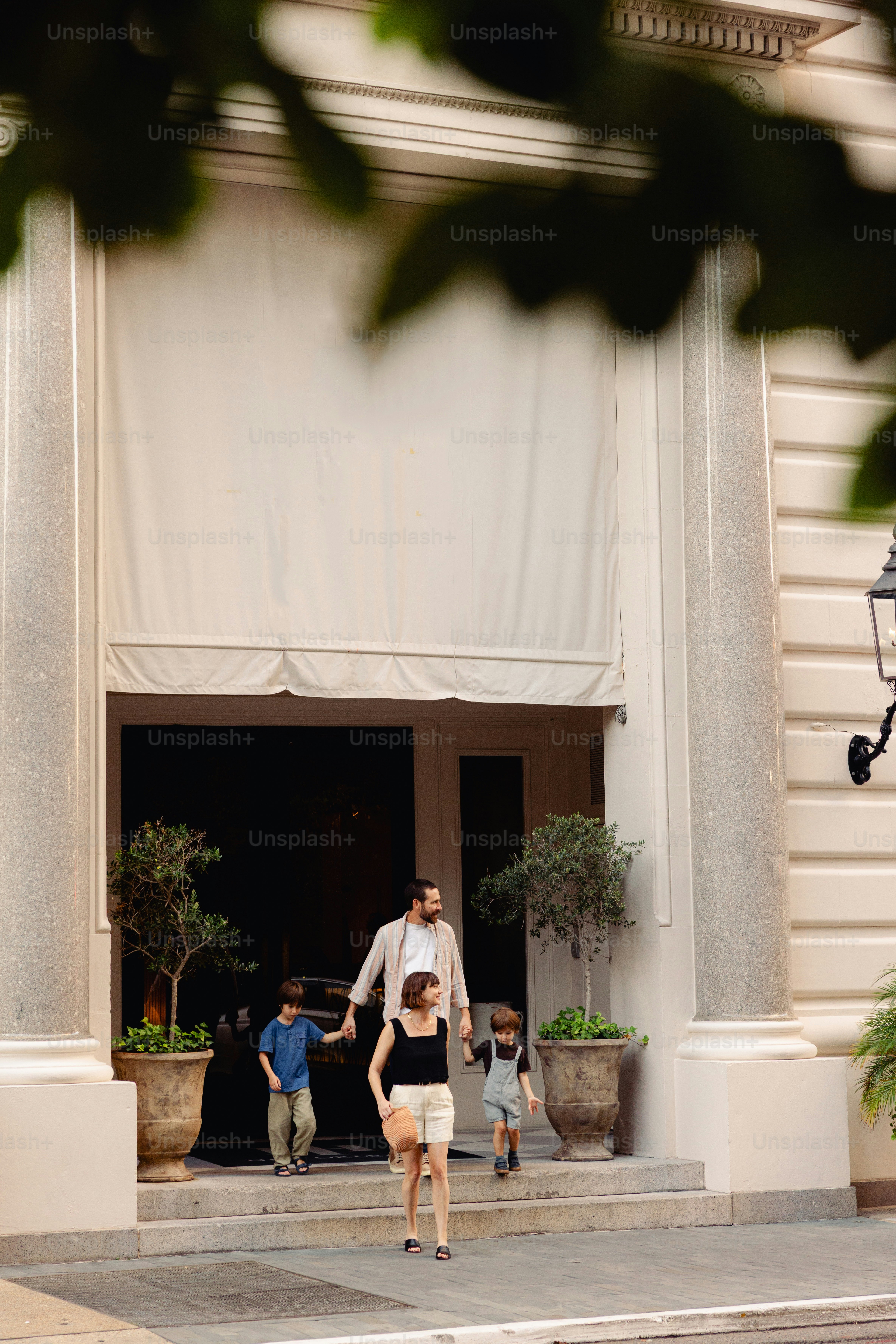 Family walking out of a grand building entrance. photo – Travel Image ...
