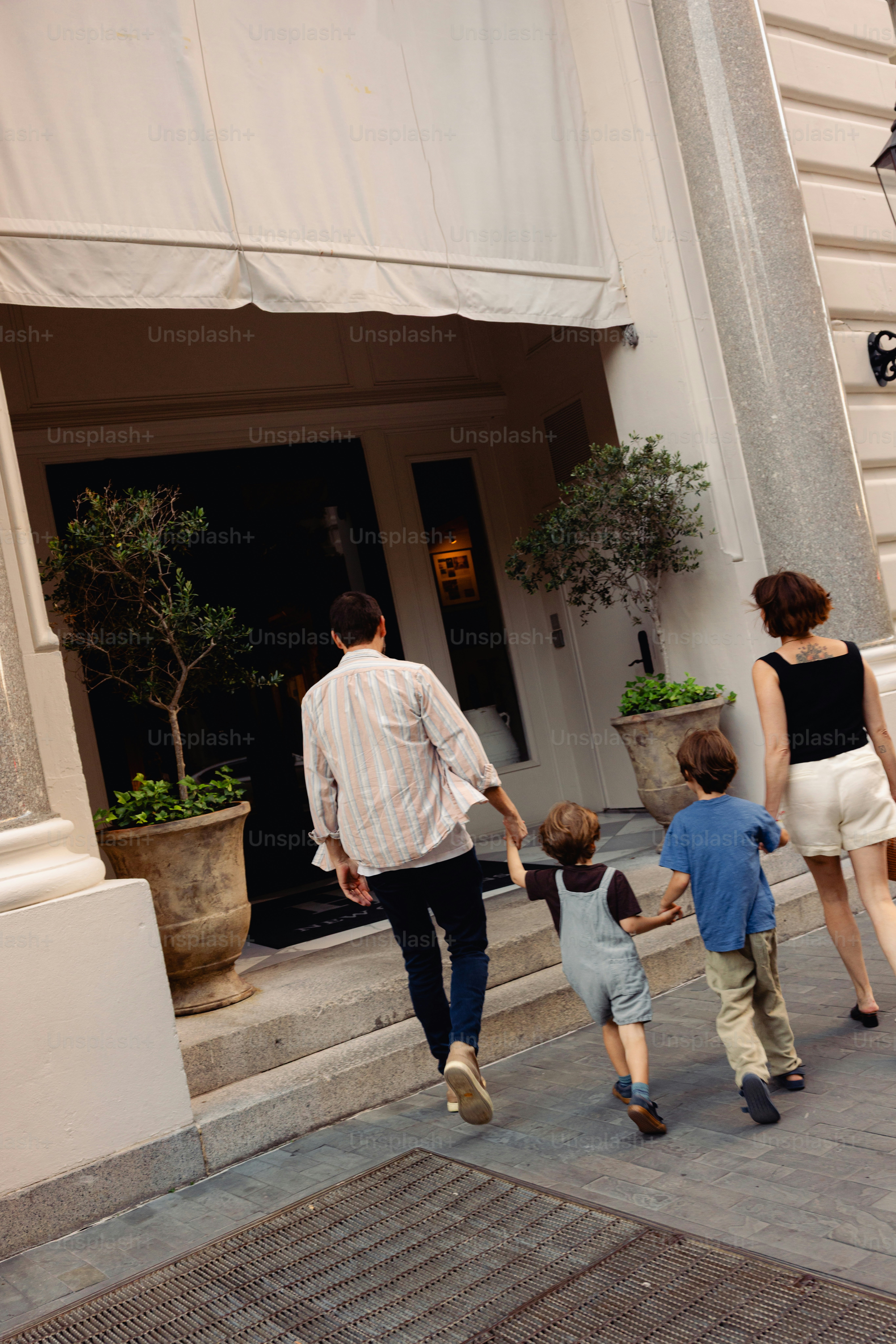 Family walking down a hotel hallway together. photo – Travel Image on ...