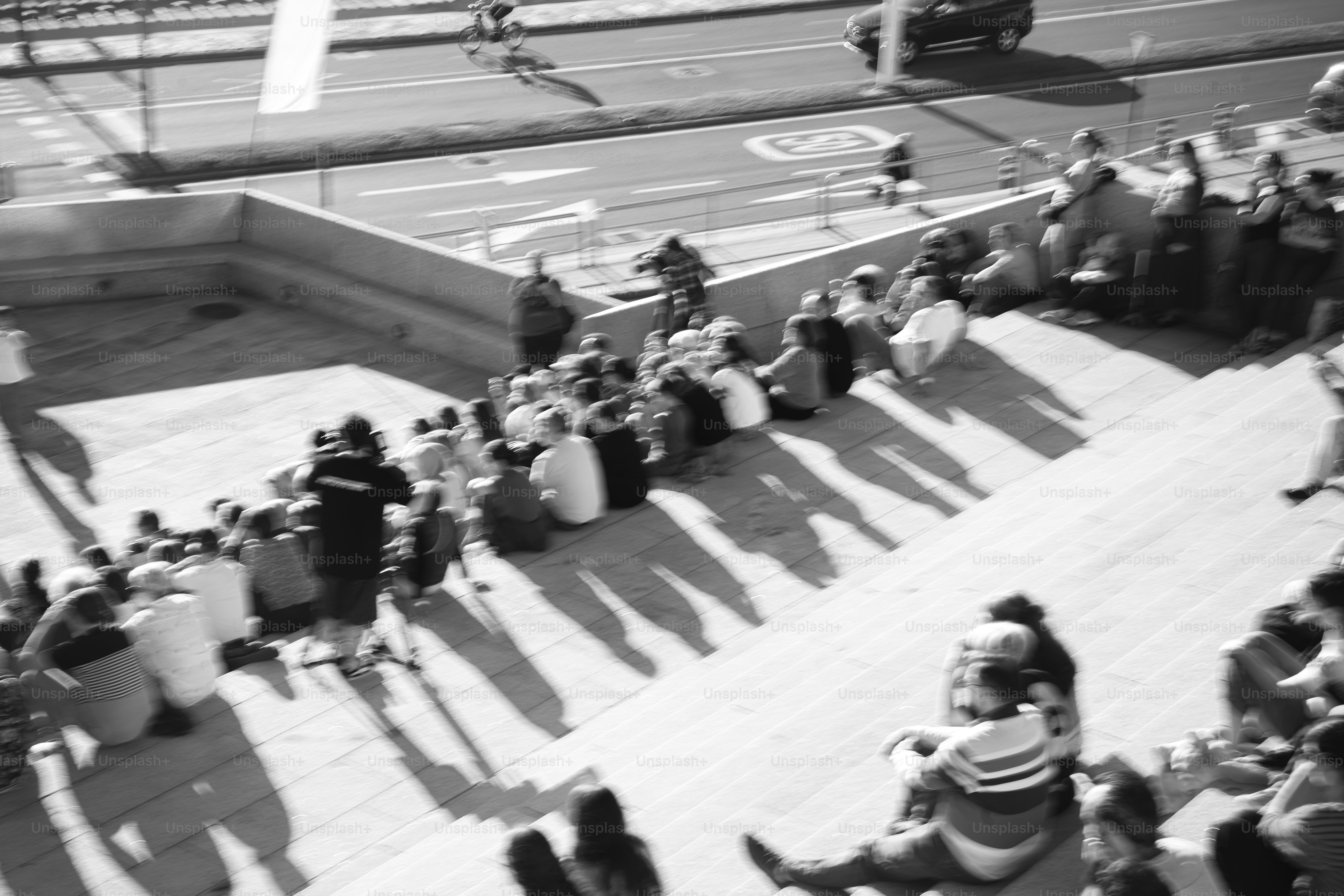 People sitting on outdoor stairs near a body of water. photo – People ...