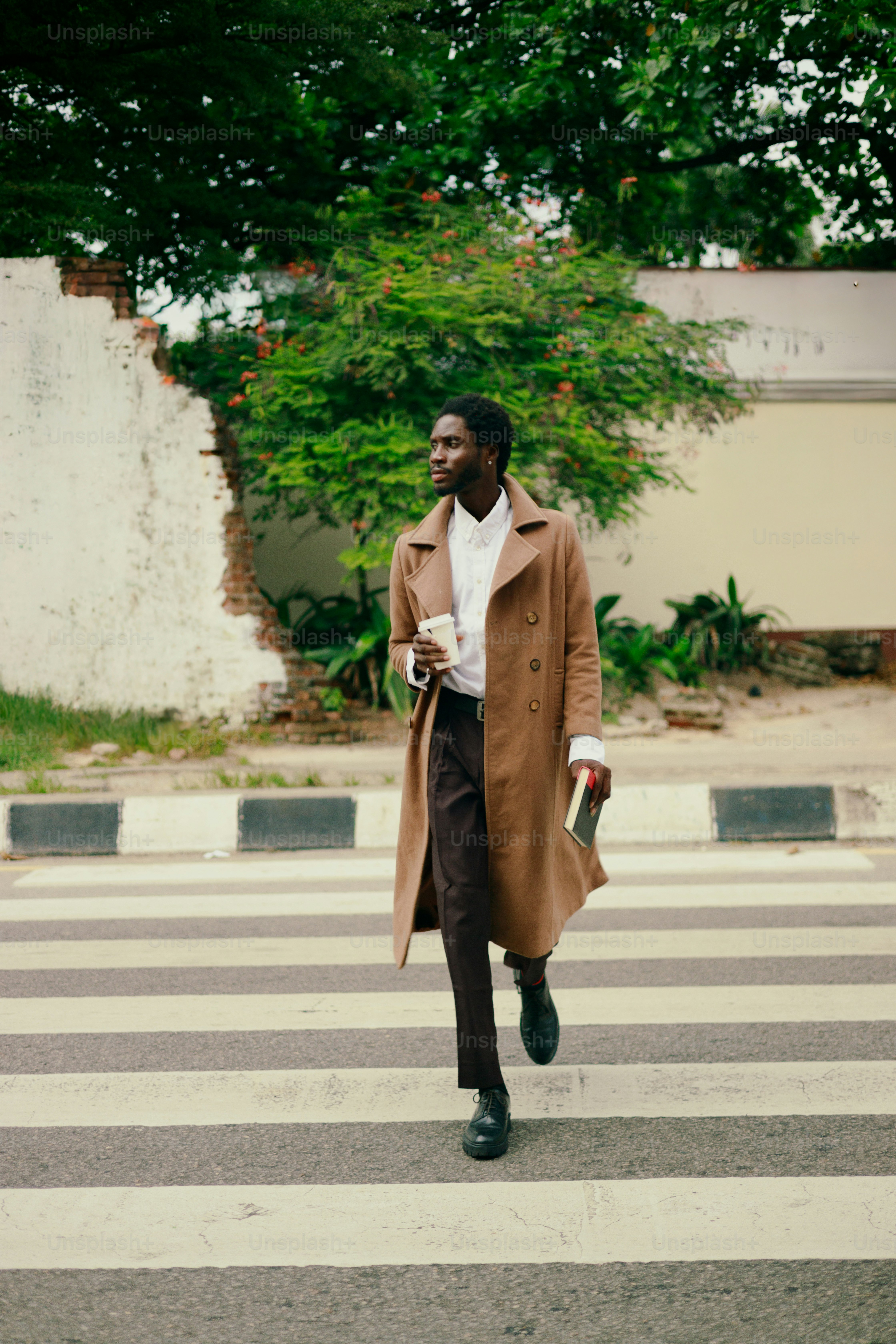 Un homme en trench-coat traverse un passage pour piétons. photo – Image ...