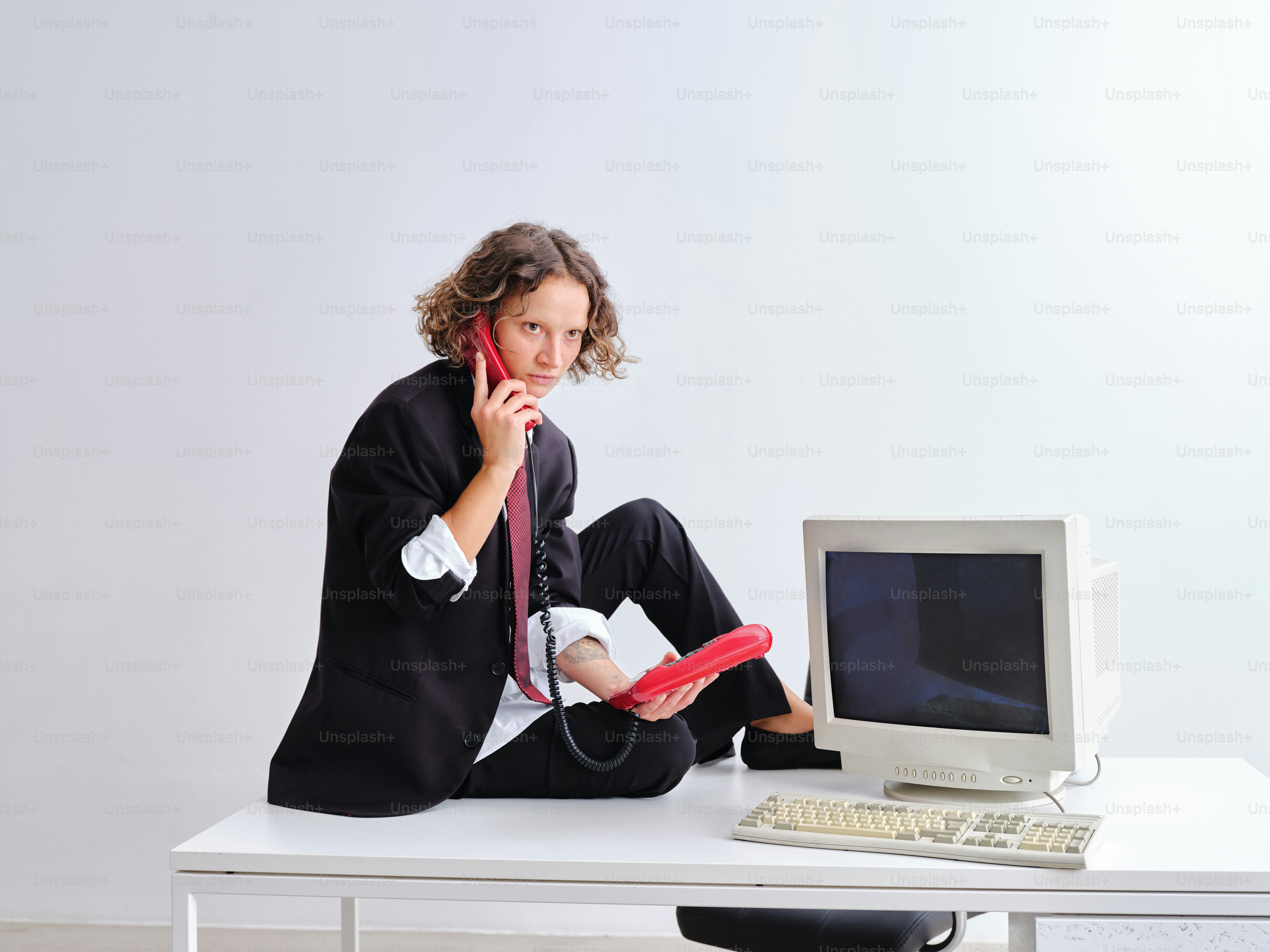 Woman in suit talks on retro phone by vintage computer. photo – Office Image on Unsplash