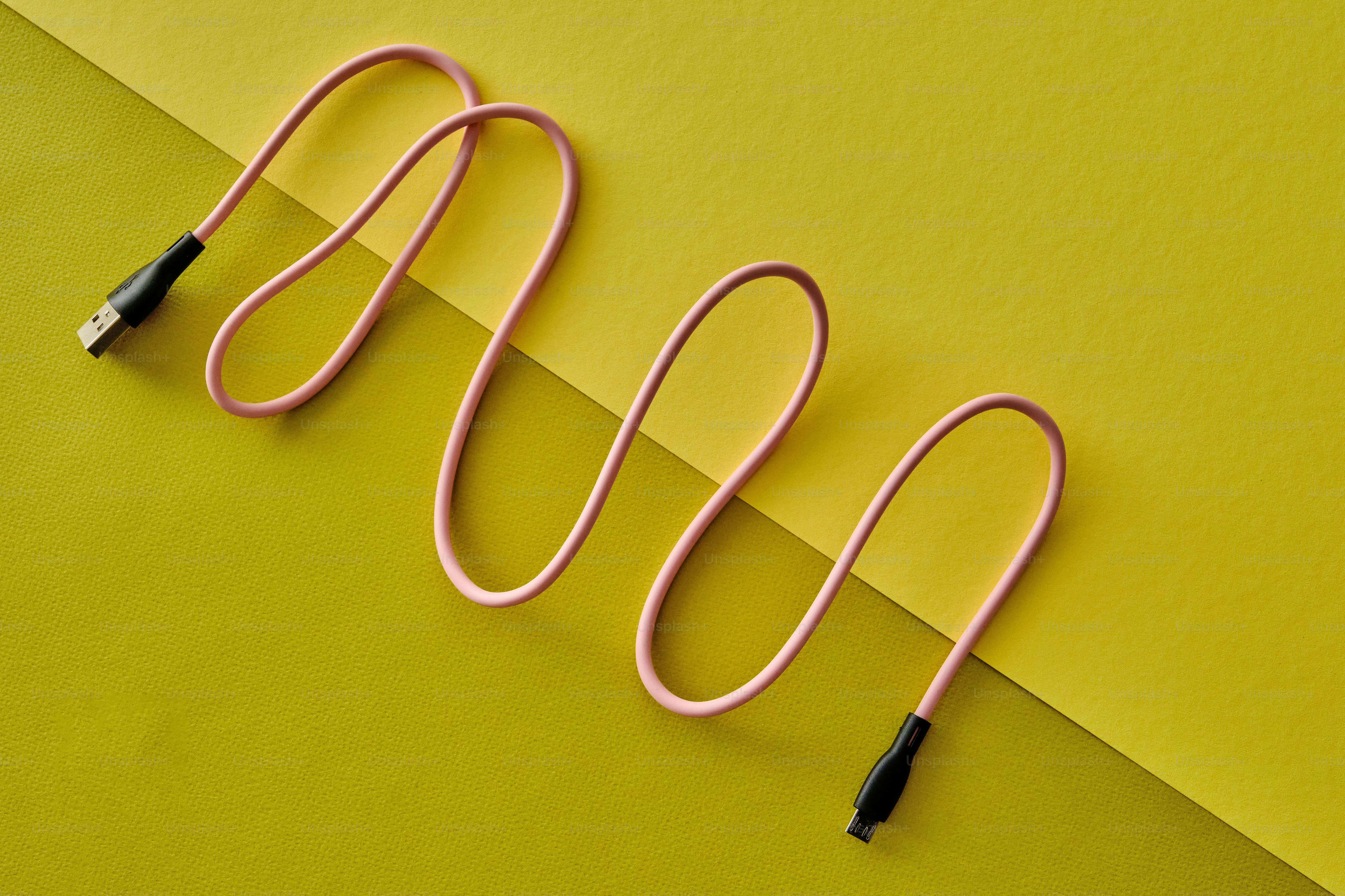 A coiled rose gold usb cable on a yellow background photo – Tech Image ...