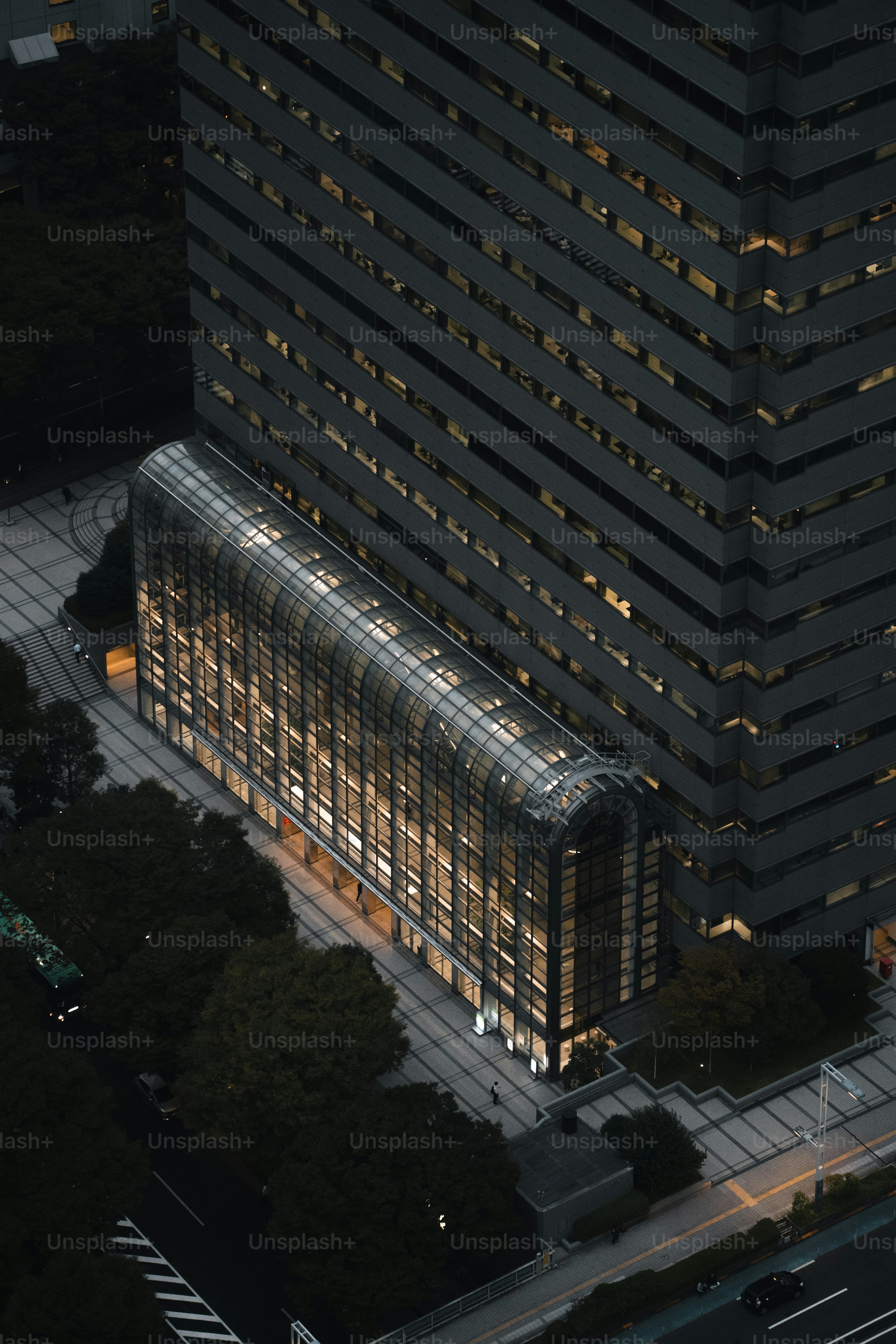 Bâtiment moderne en verre adjacent à une grande tour de bureaux. photo ...