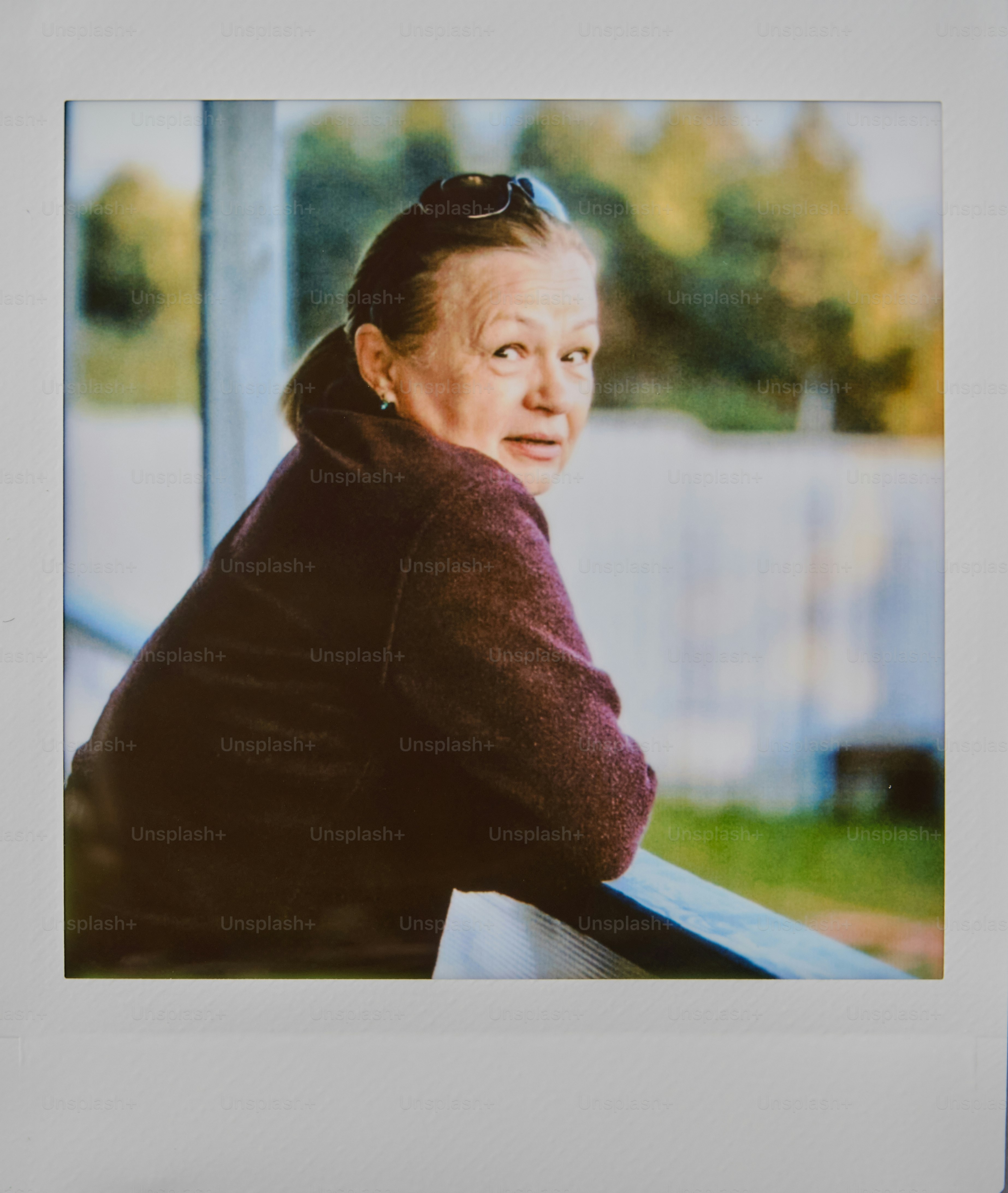 Elderly woman with glasses on porch looks over shoulder. photo ...