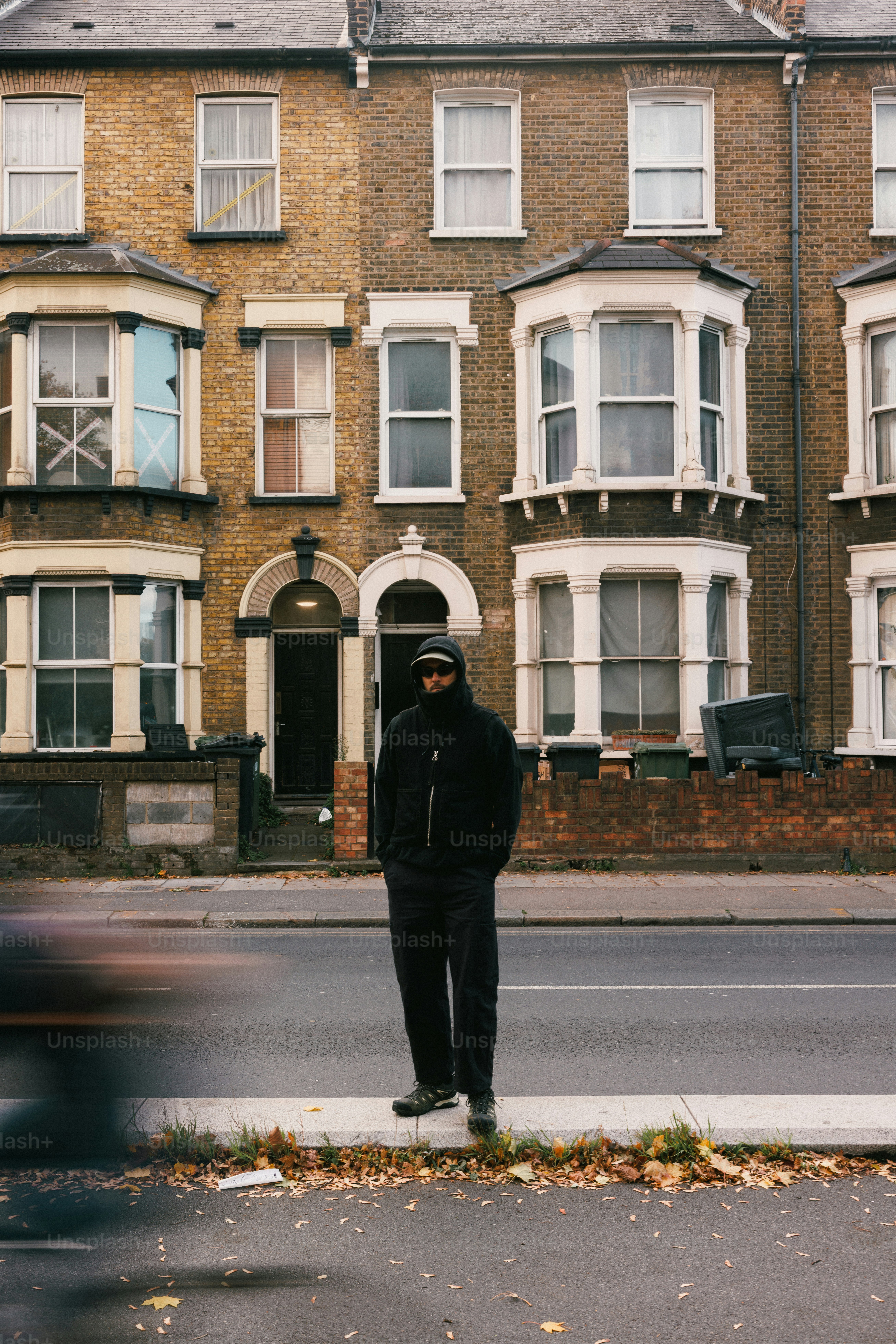 Man standing on street in front of brick houses photo – Fashion Image ...