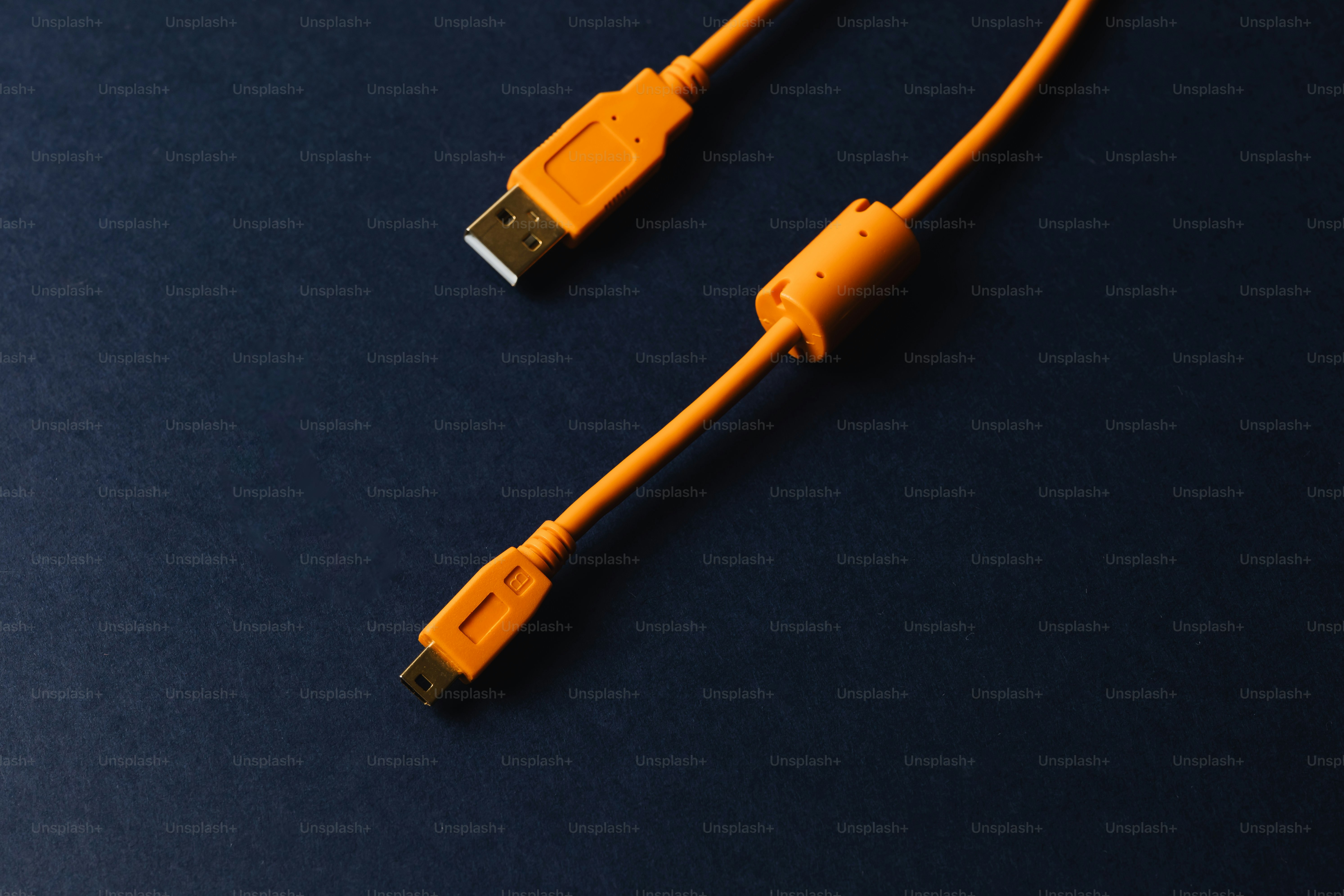 Two orange usb cables on dark background photo – Technology Image on ...