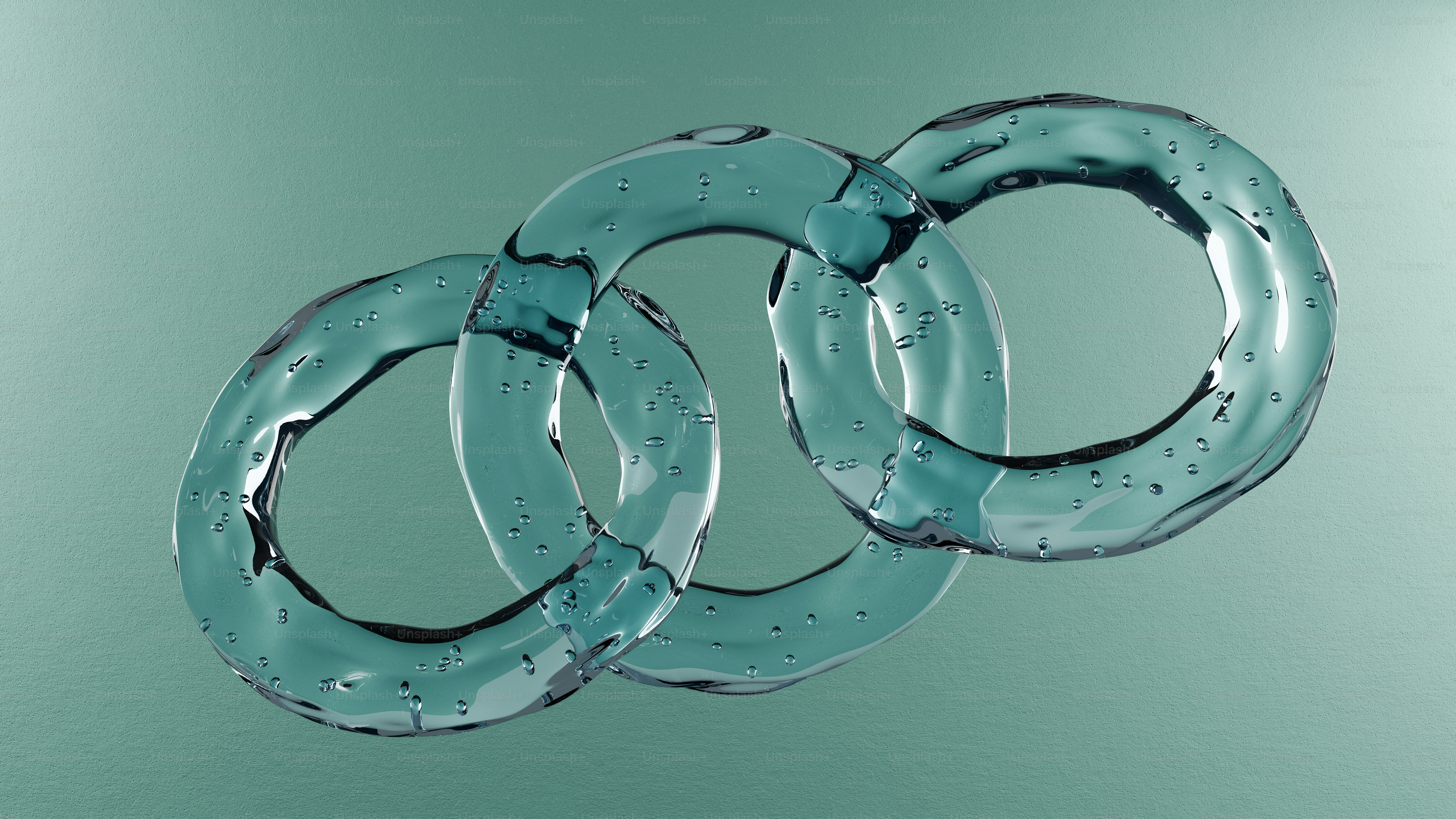 Three interlocking liquid rings on a teal background photo – 3d render ...