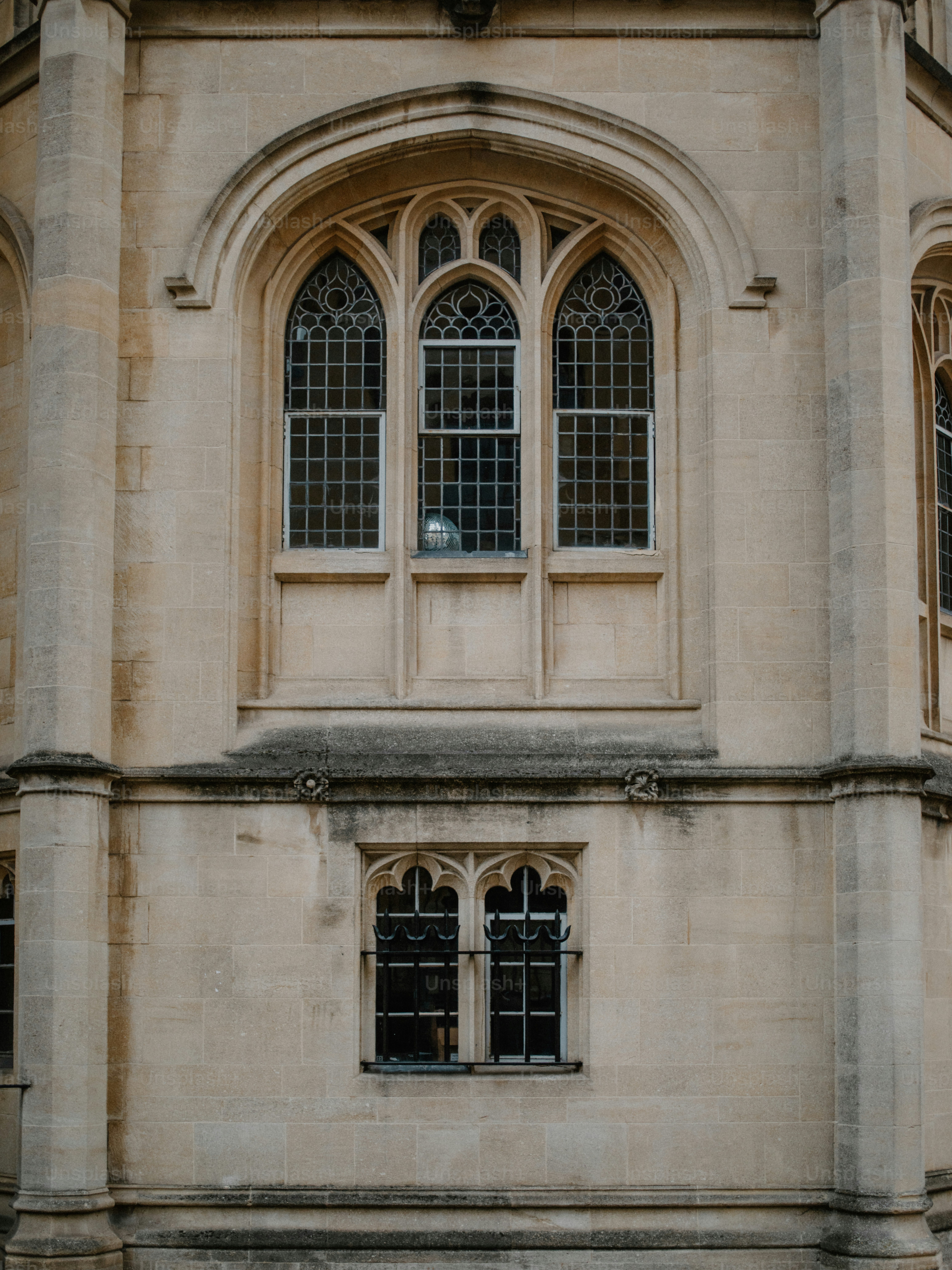 Old stone building with large windows and birds flying. photo – England ...