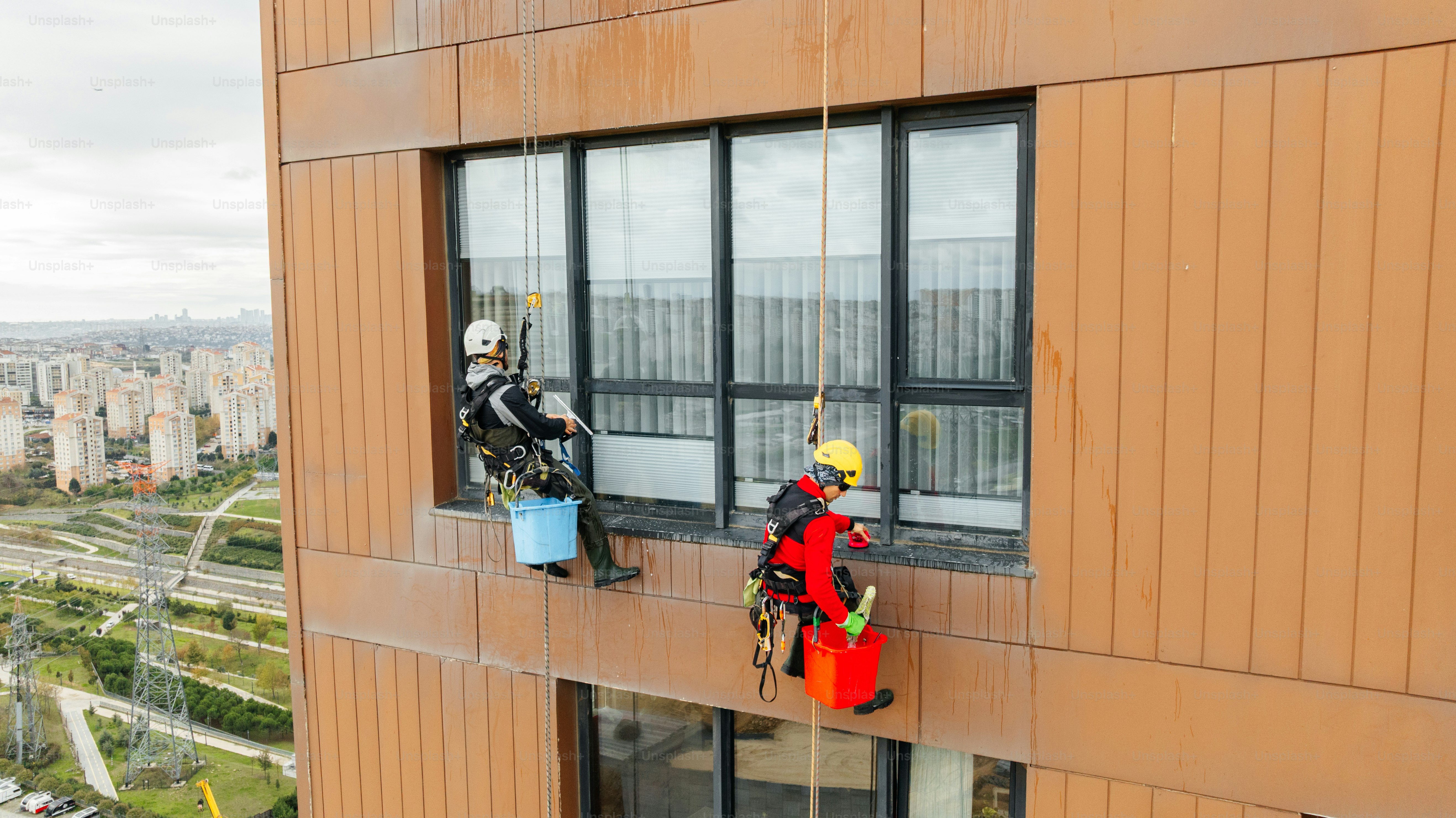 Two window cleaners rappelling down a building photo – Cityscape Image ...