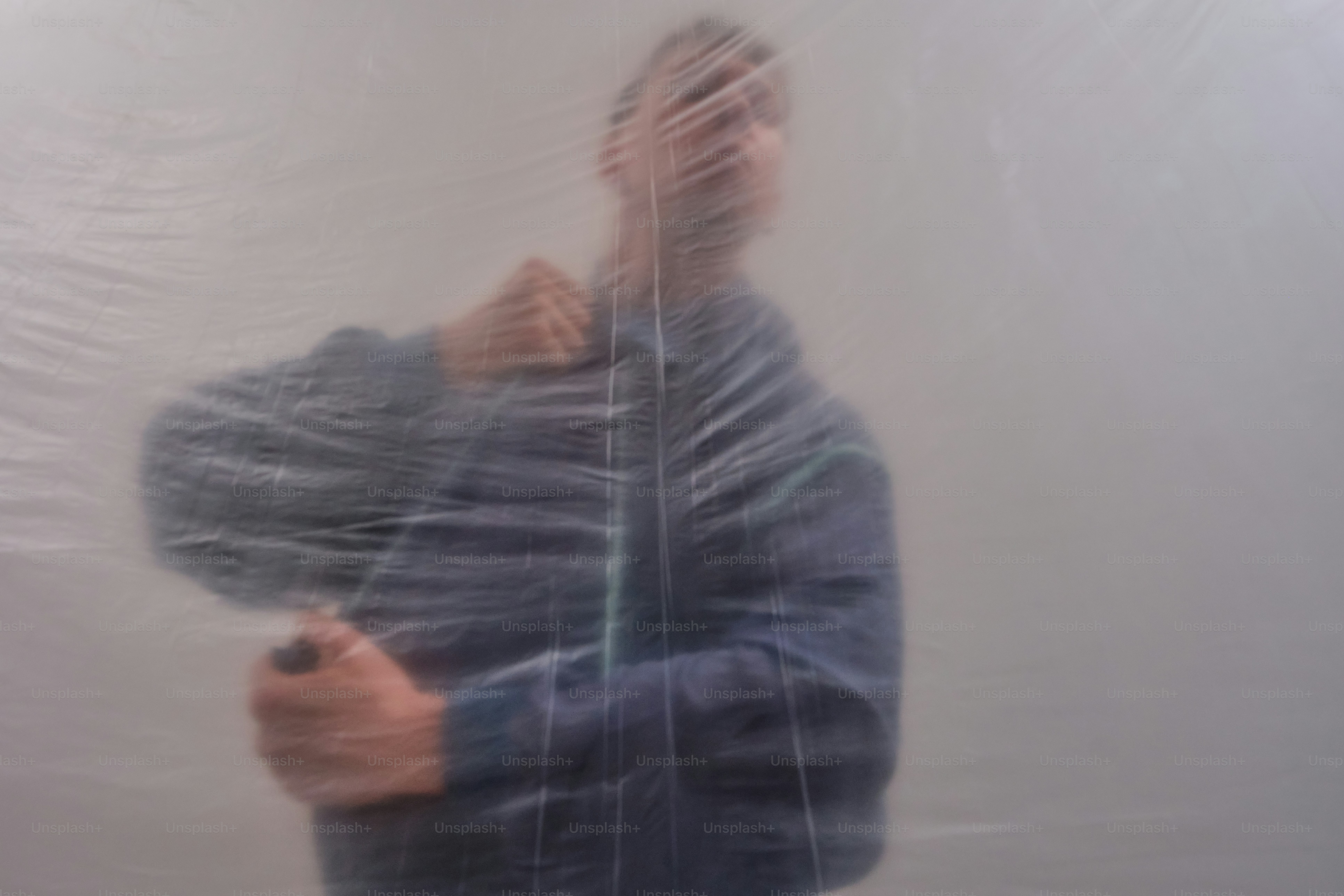 Man wrapped in clear plastic wrap, struggling to break free. photo ...