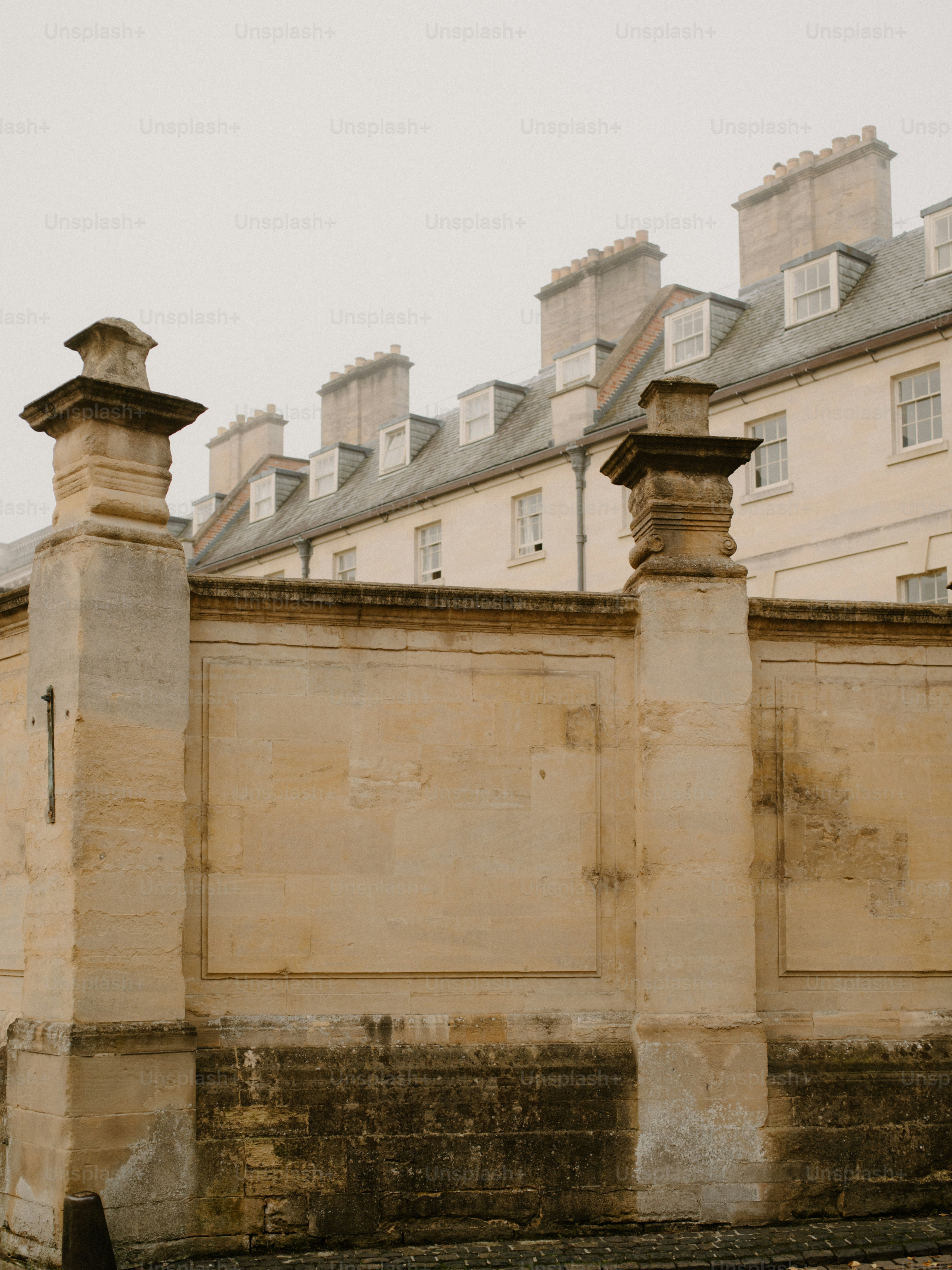 Stone wall with historic buildings in the background photo ...