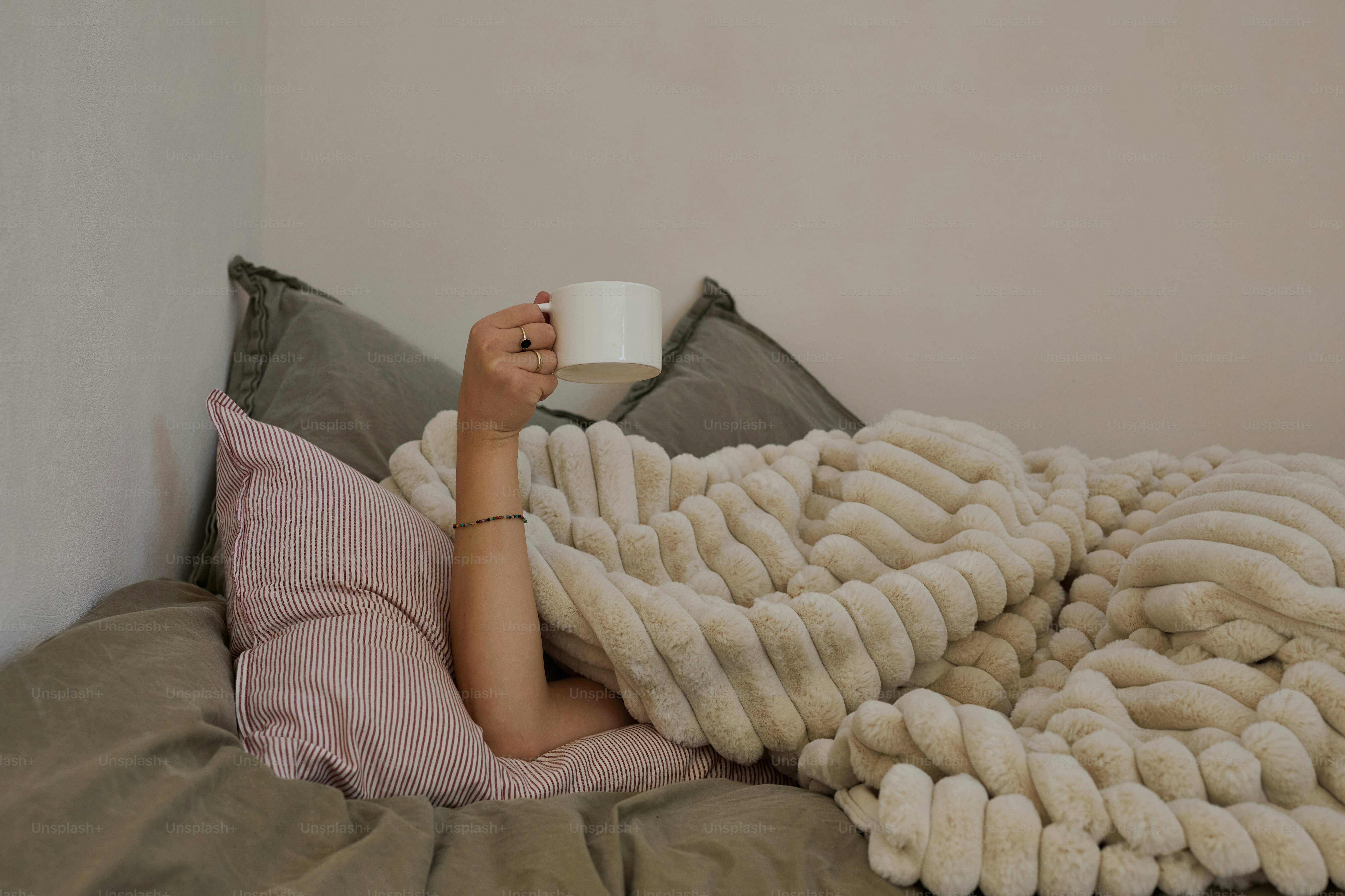 Person holding a mug while covered in a blanket photo – Blanket Image ...
