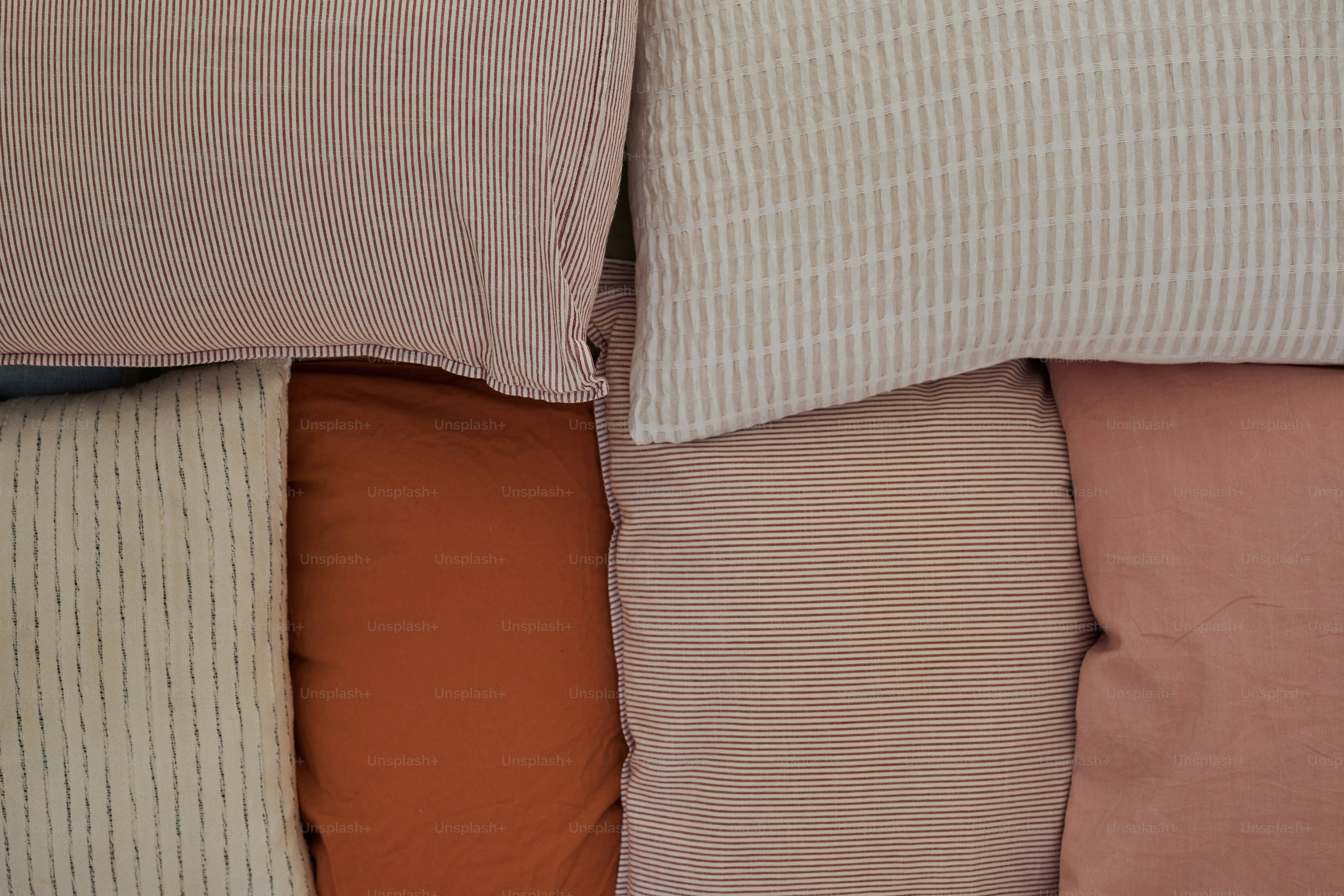 Stack of pillows and a textured blanket on a bed photo – Blanket Image ...