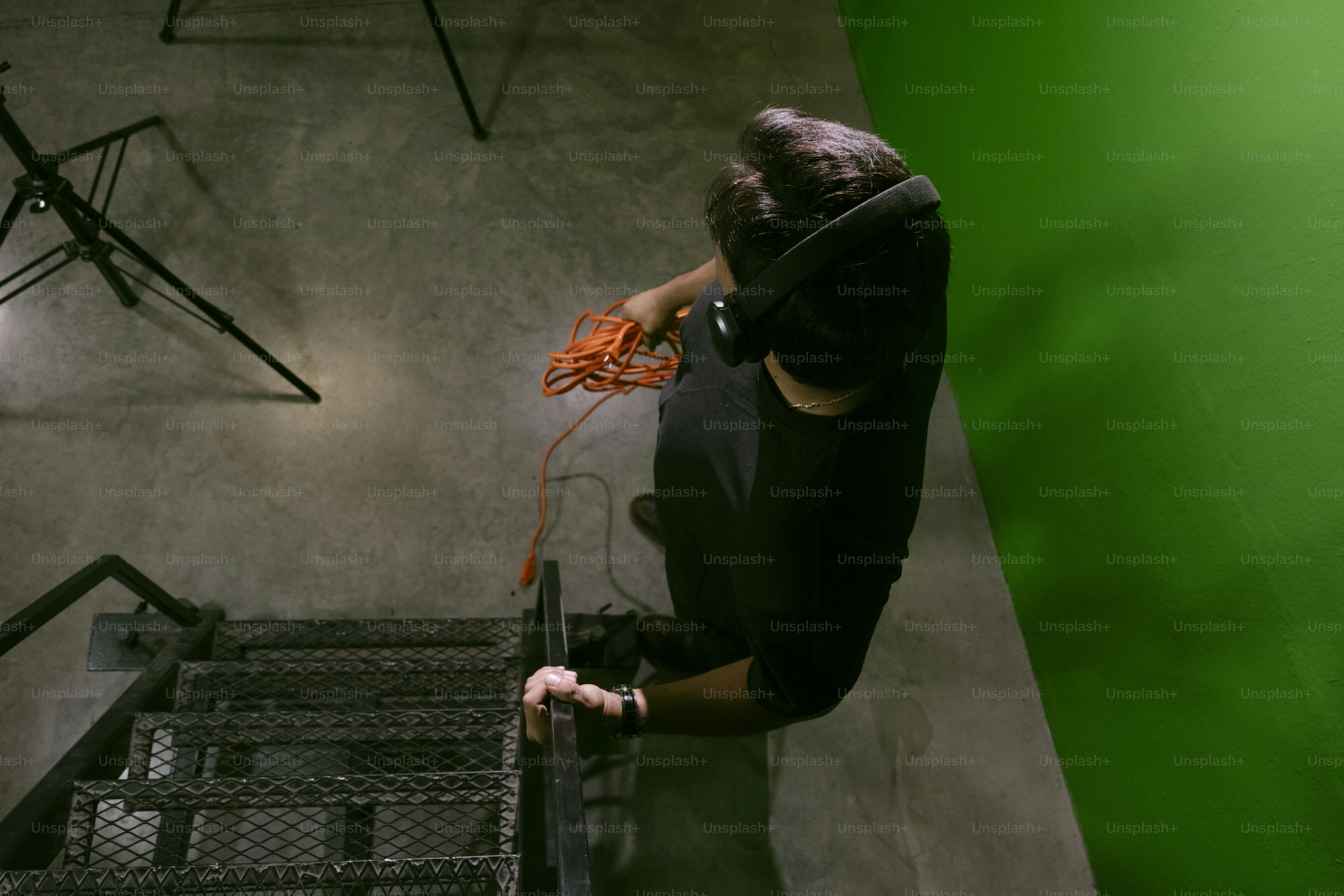 Man holding orange cables on metal stairs photo – Bts Image on Unsplash