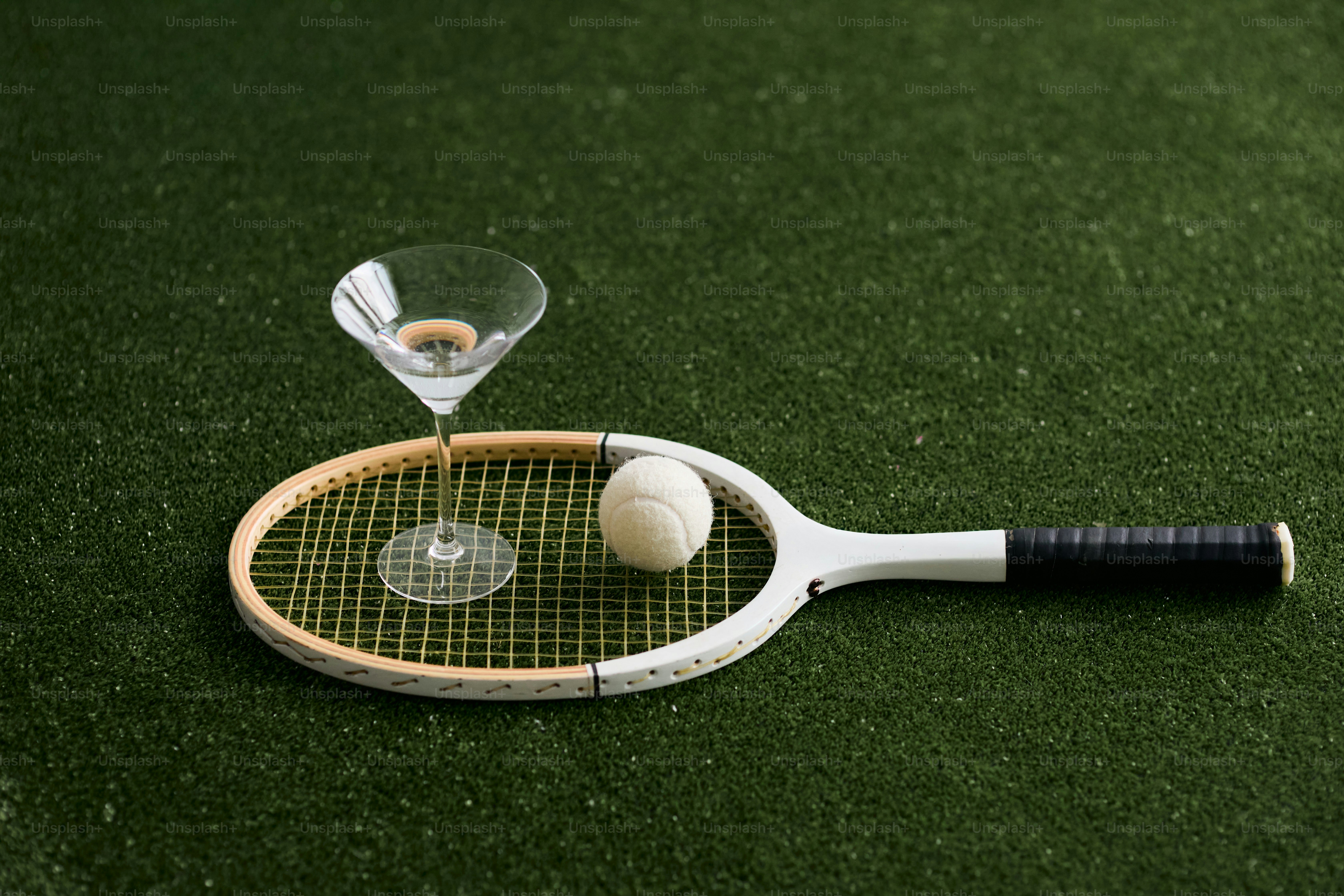 Green book with jewelry, watch, keys, and tennis racket. photo ...