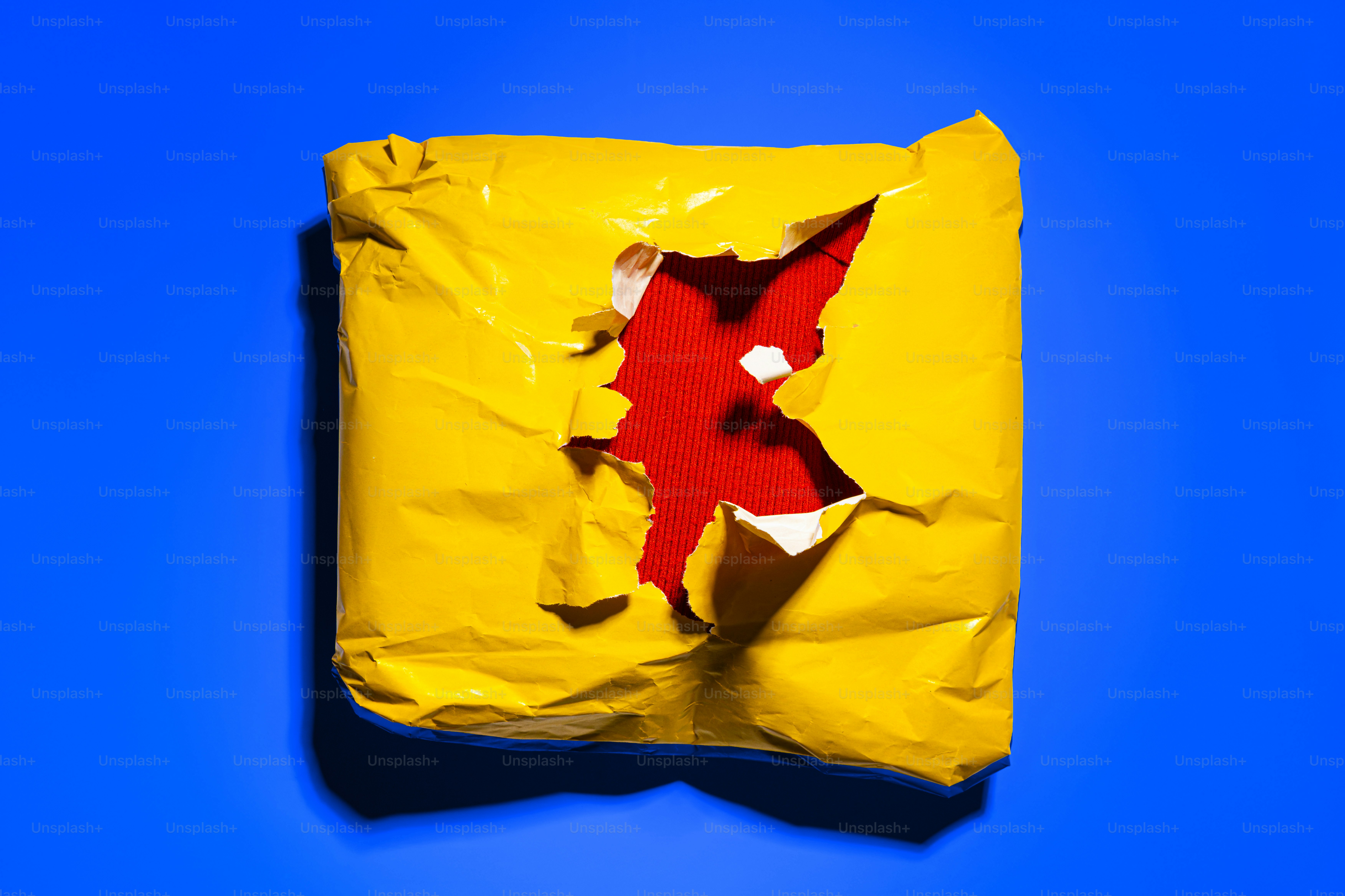 A yellow package ripped open revealing red inside photo – Celebration ...
