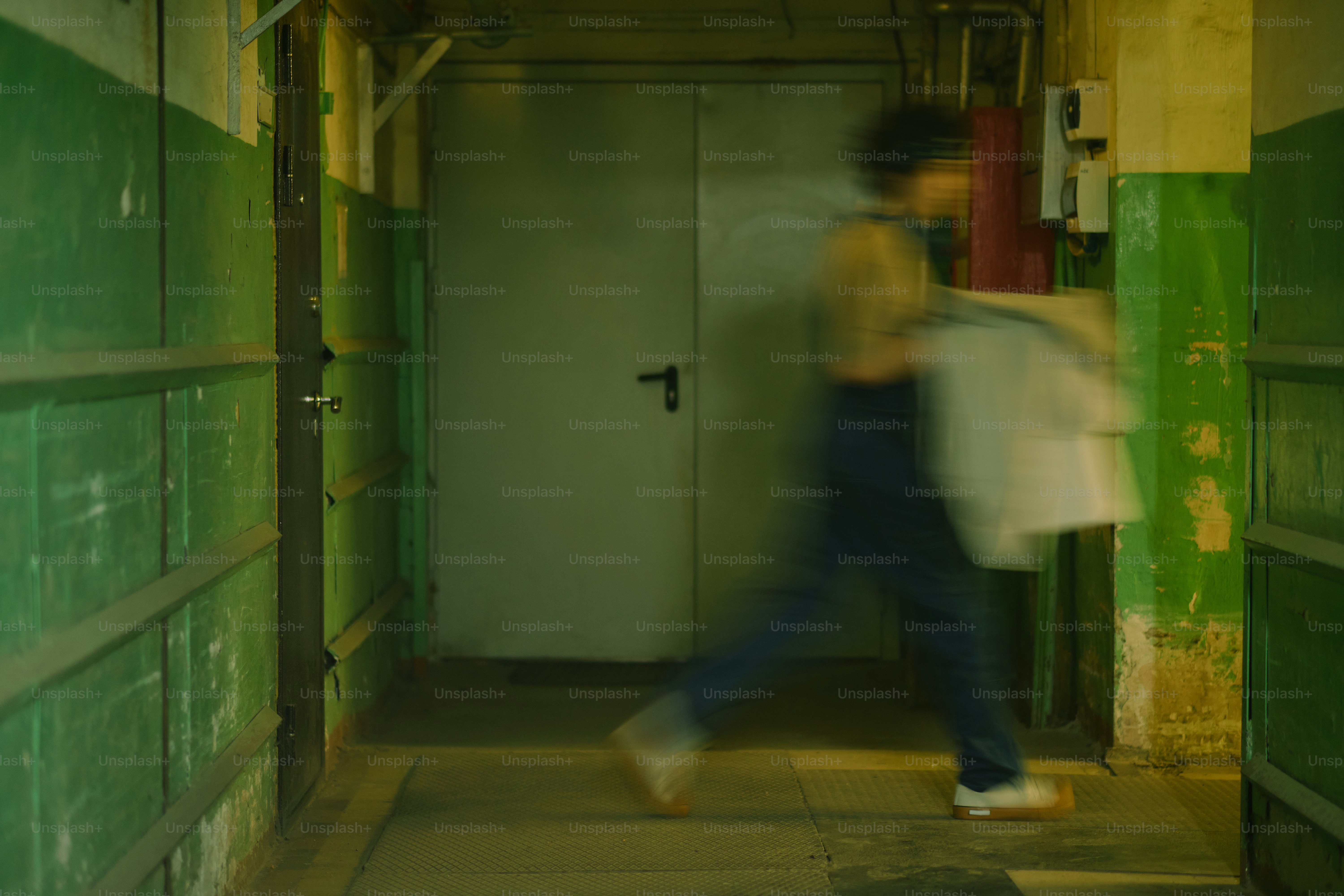 Person walking down a dimly lit hallway. photo – Man Image on Unsplash