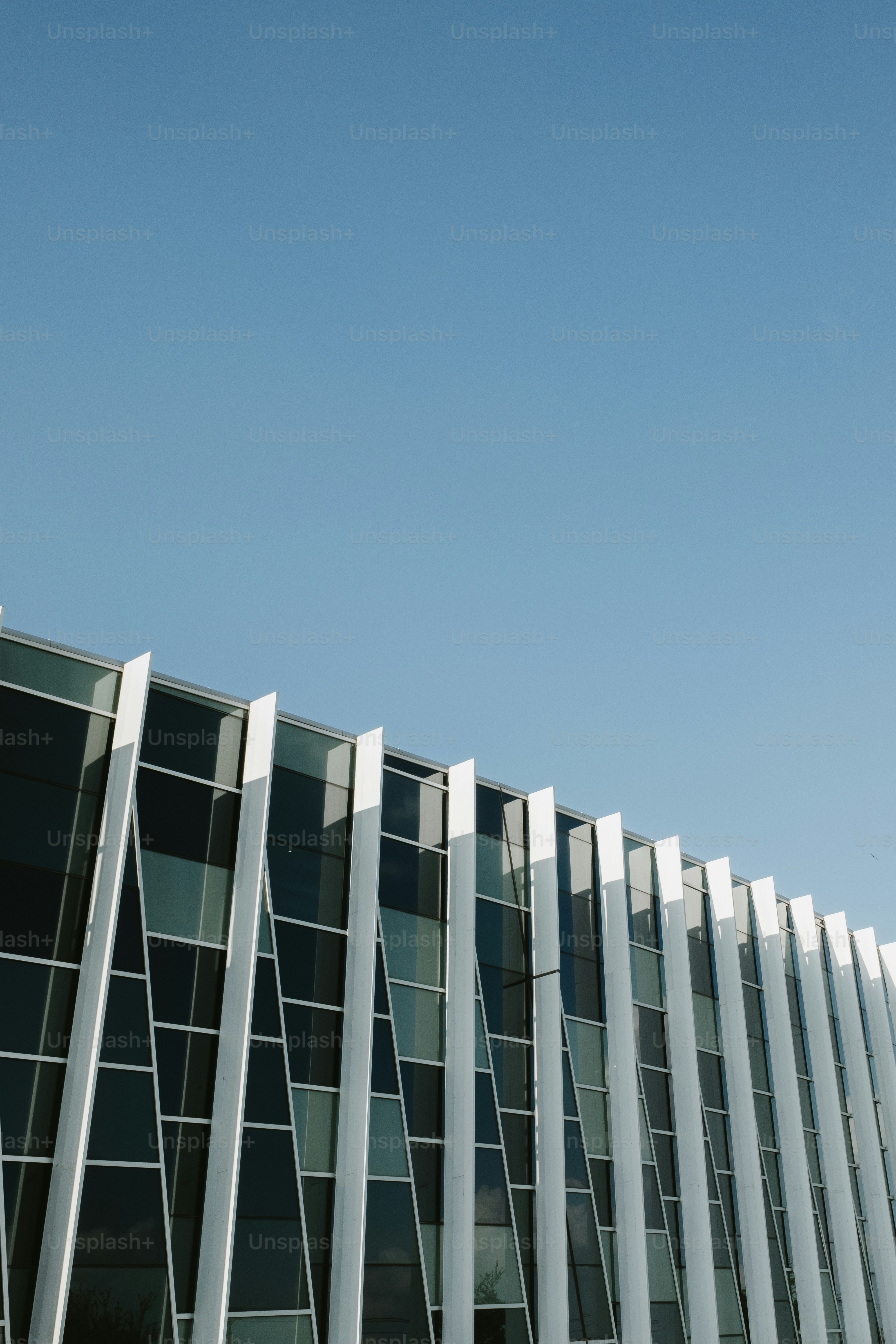 Bâtiment moderne avec façade vitrée sur un ciel bleu clair photo ...