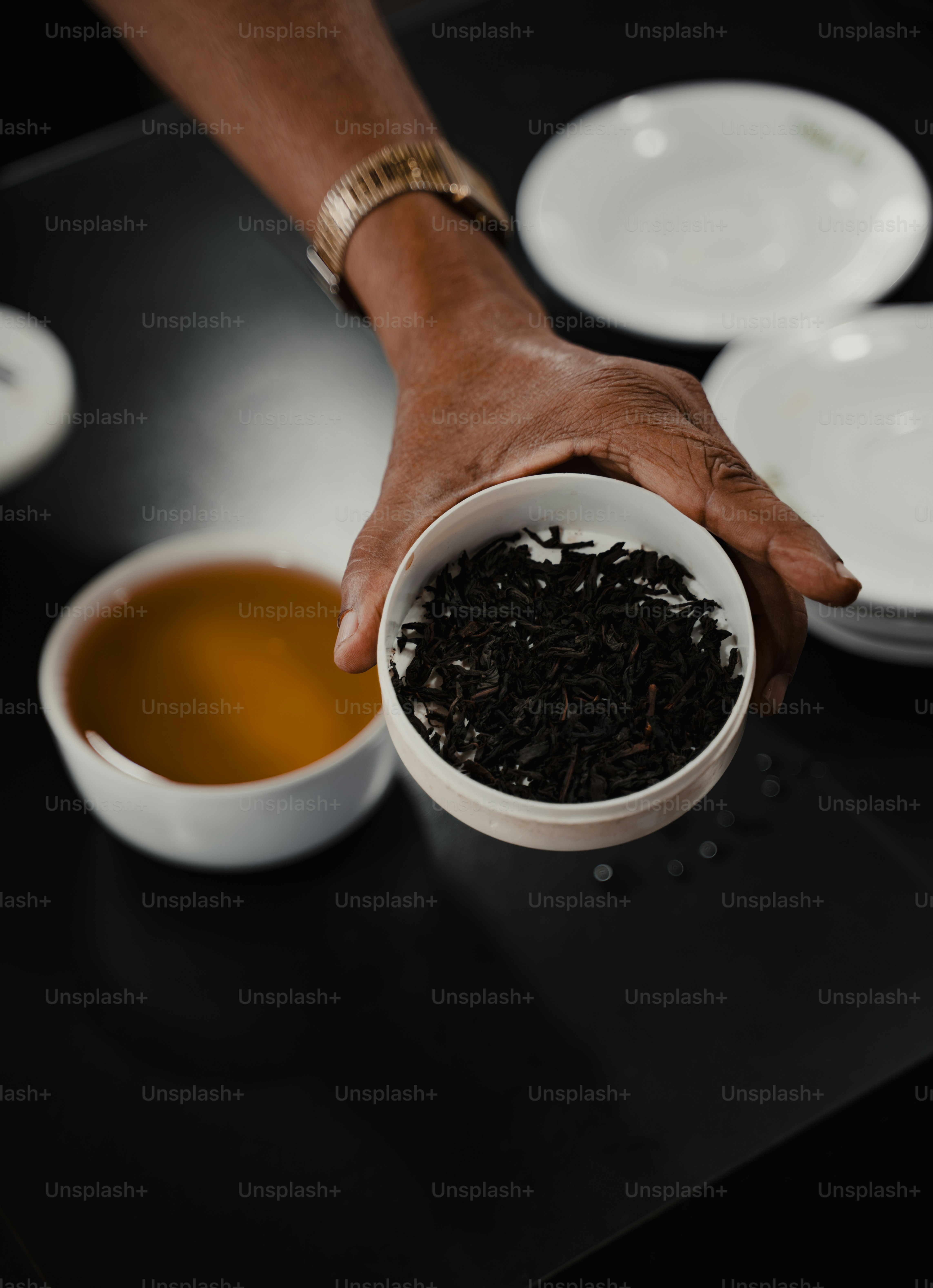 Hand holding loose leaf tea next to brewed tea. photo – Drink Image on ...
