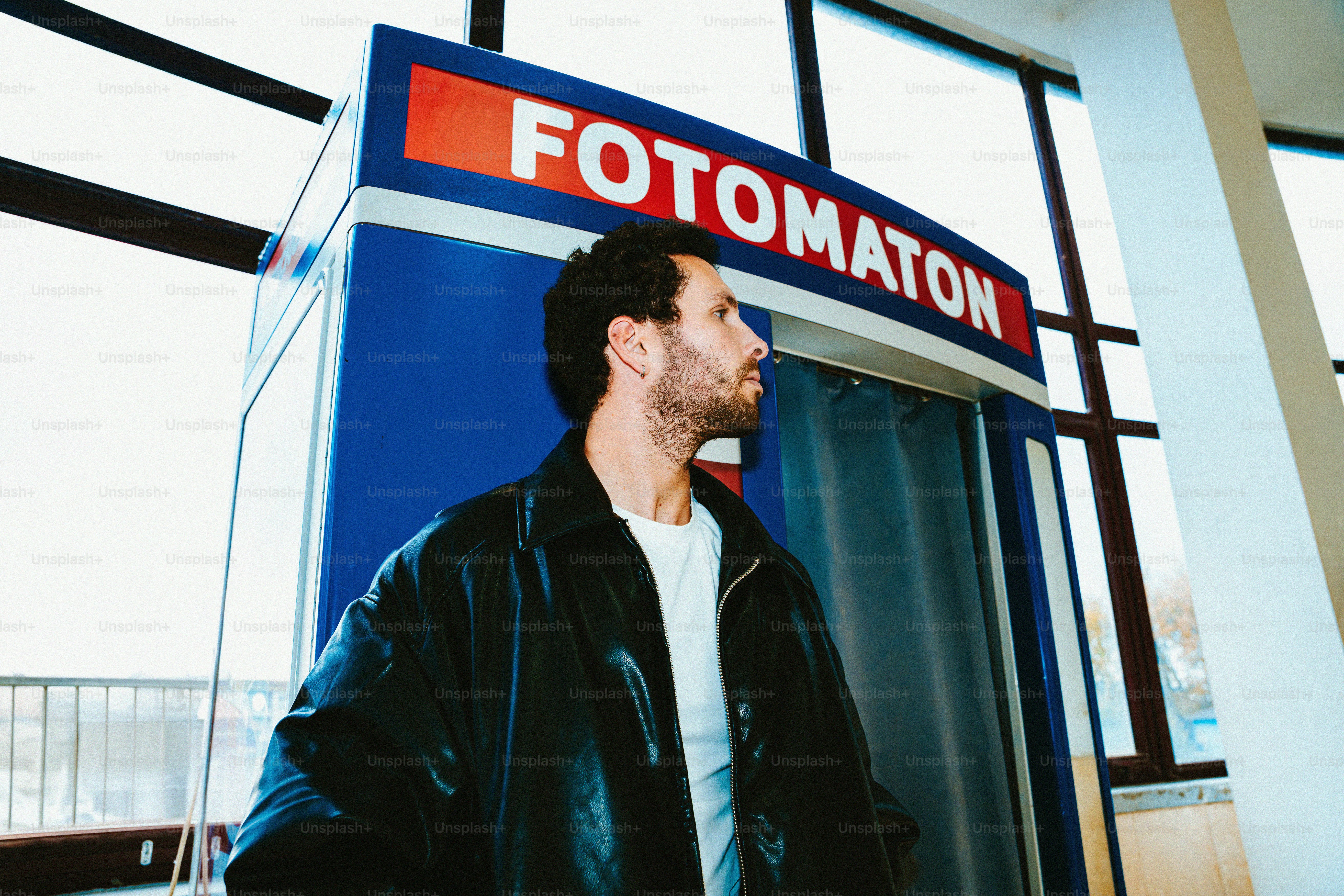 Man standing next to a fotomaton booth photo – Image on Unsplash