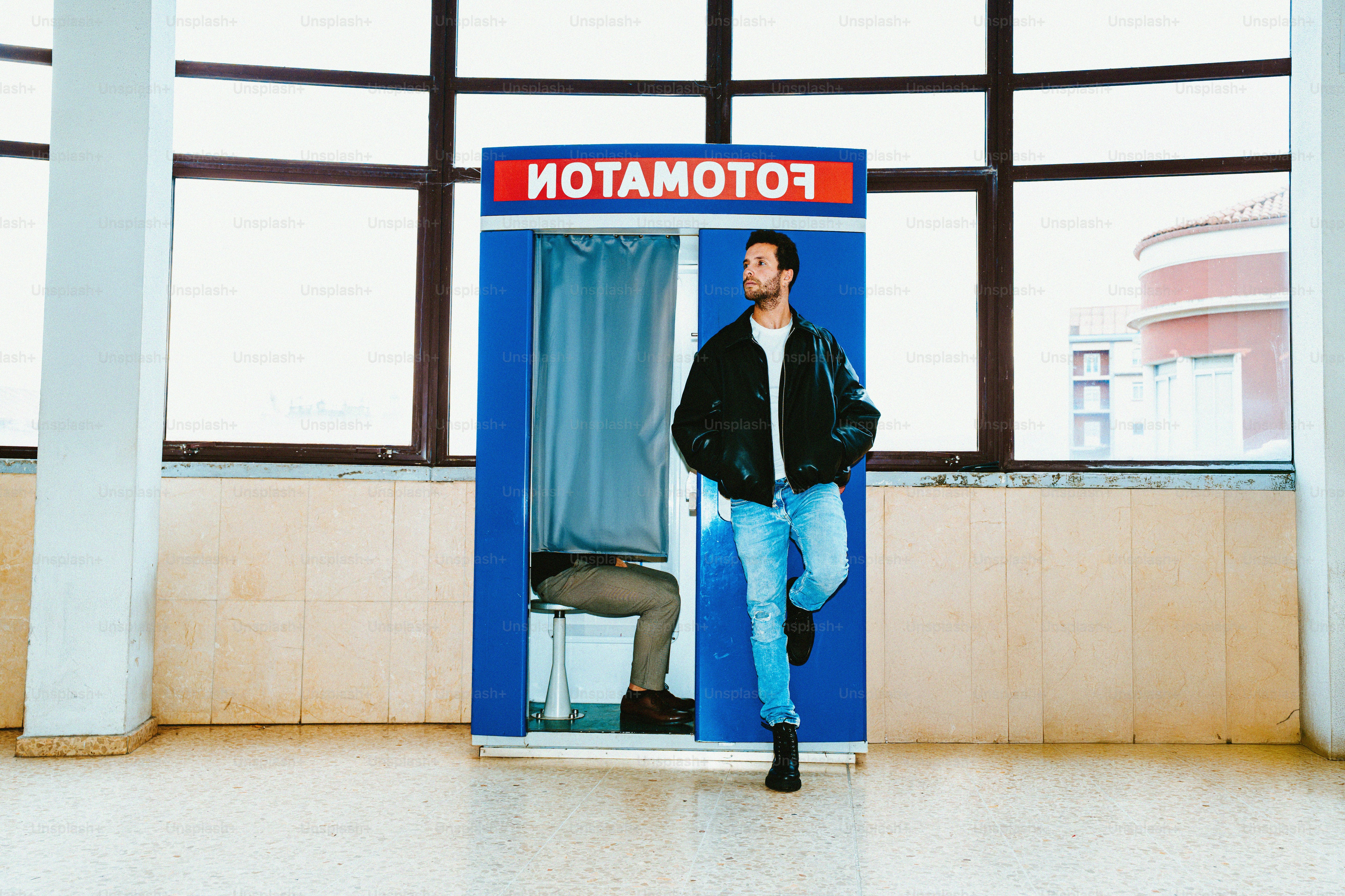 Man standing next to a fotomaton booth photo – Image on Unsplash