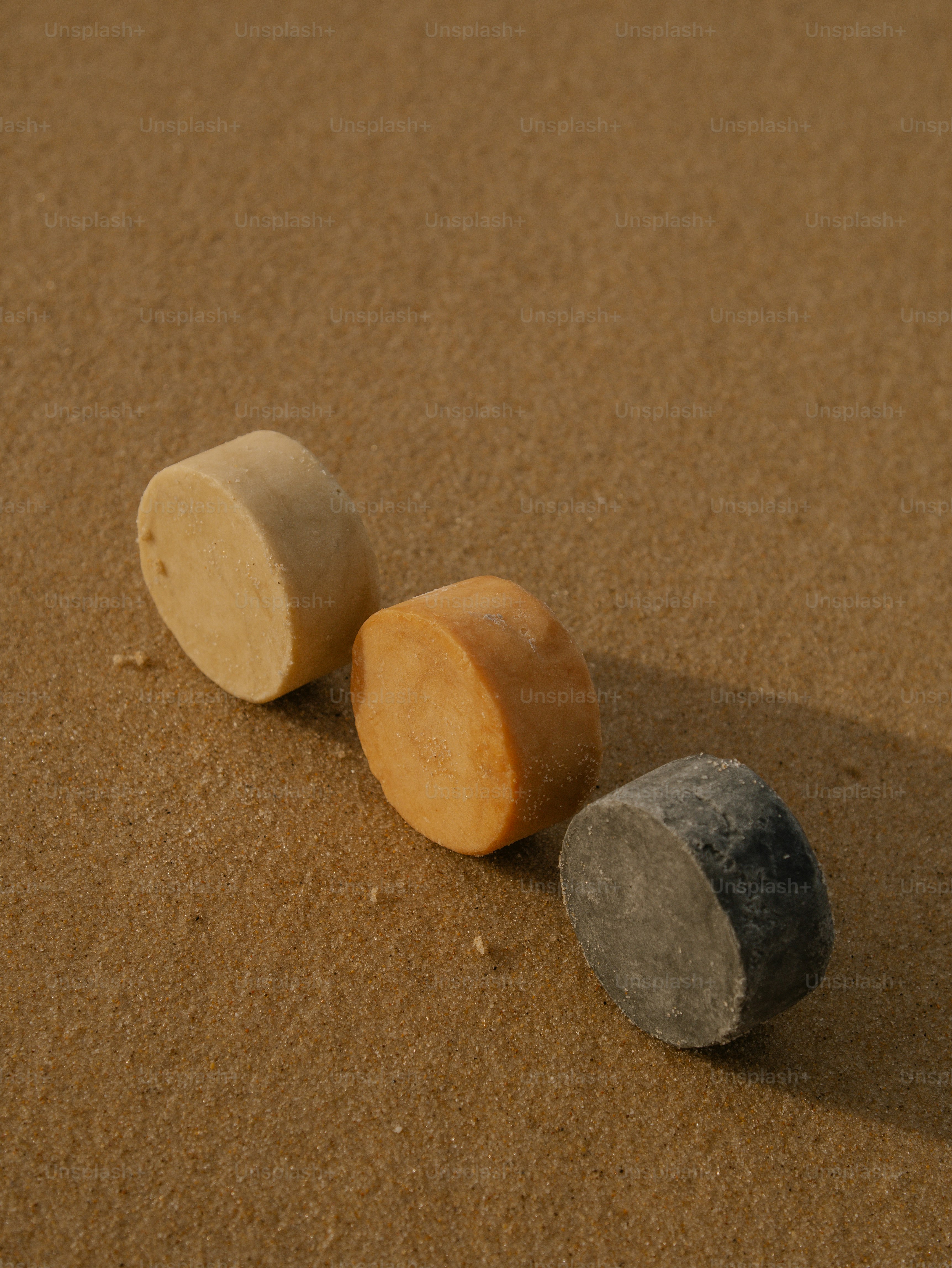 Three small cylindrical objects on sand photo – Beauty Image on Unsplash