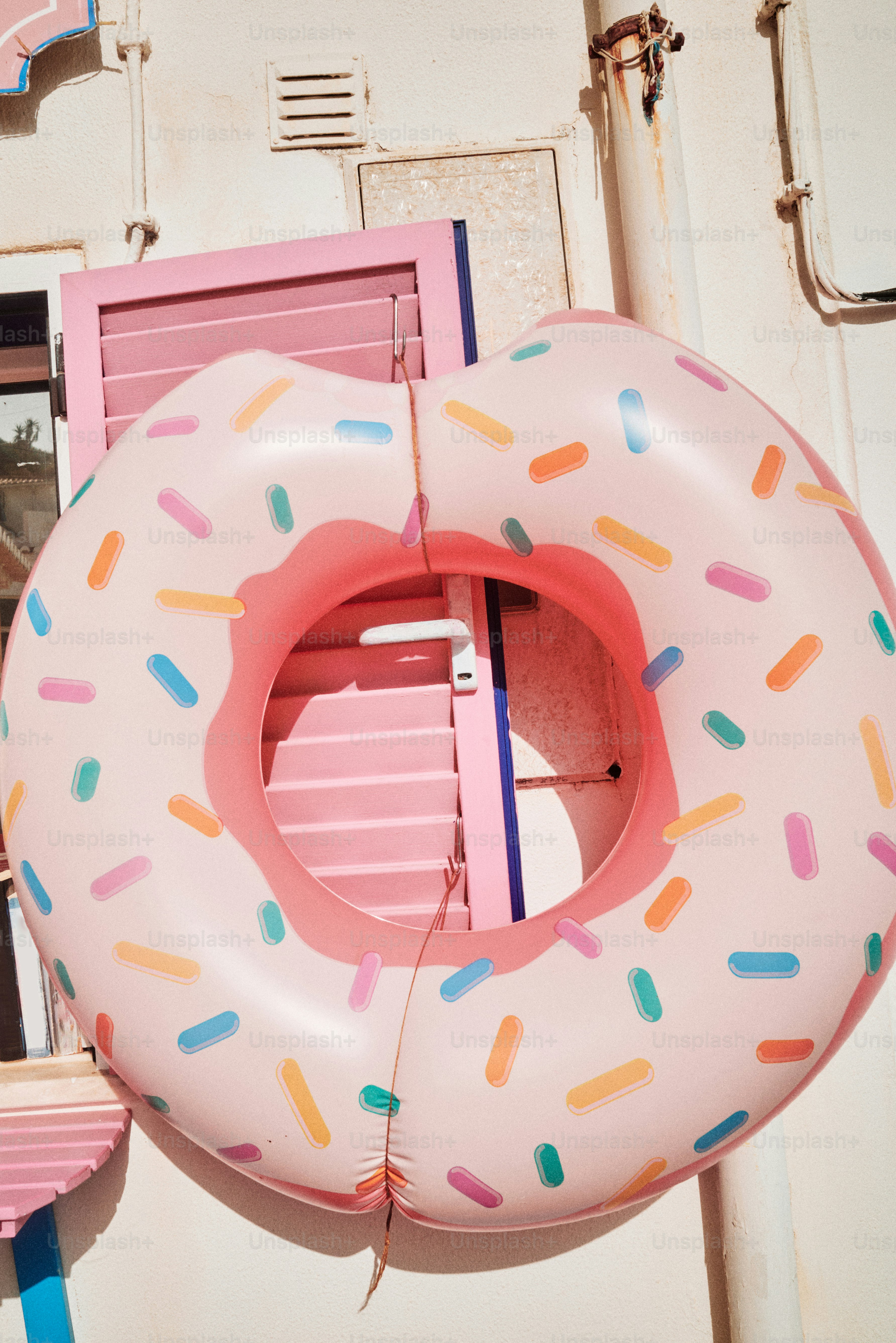 Inflatable donut float hanging on a wall photo – Summer Image on Unsplash