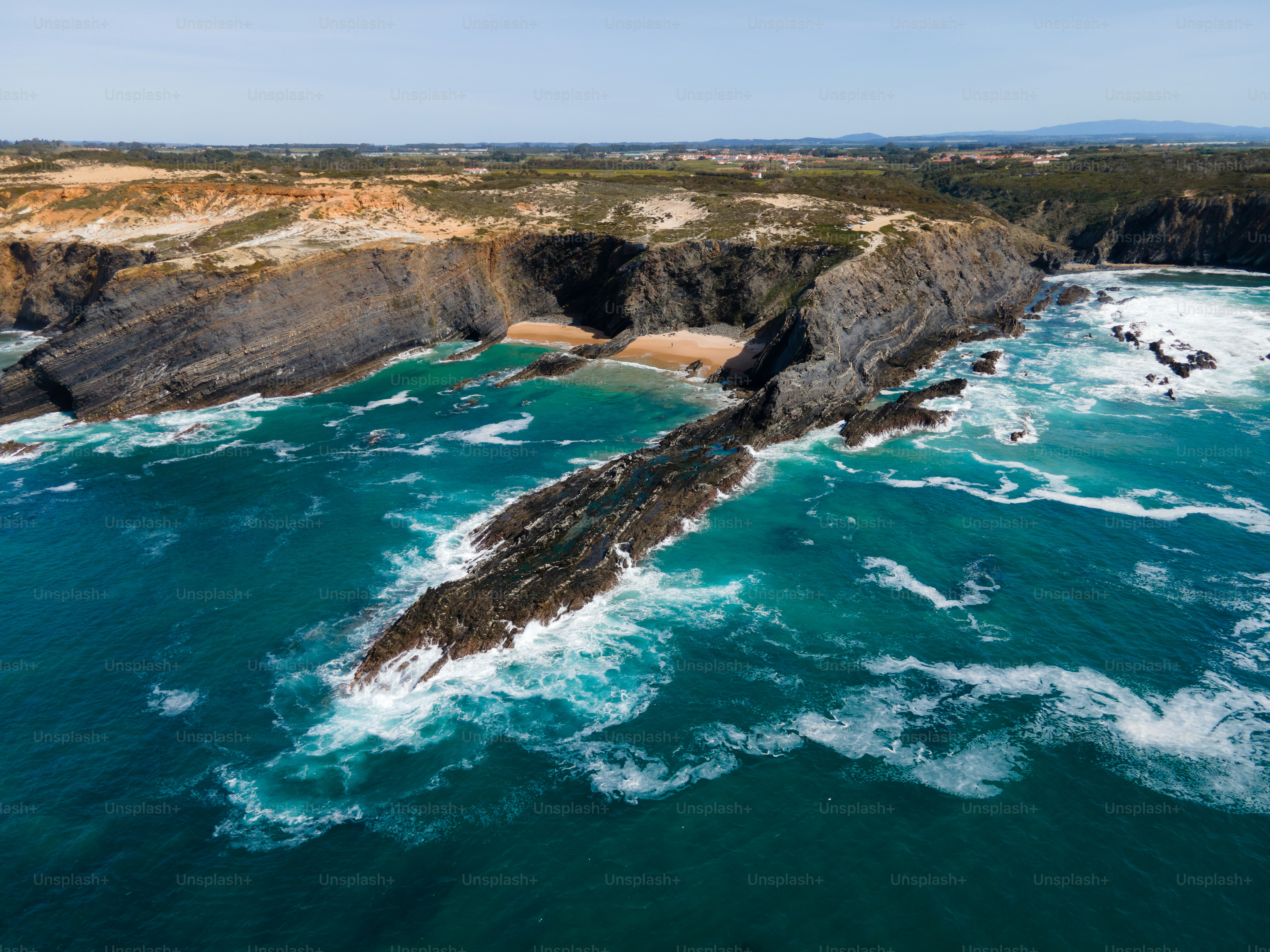 Rocky coastline with crashing waves and a sandy cove. photo – Beach ...