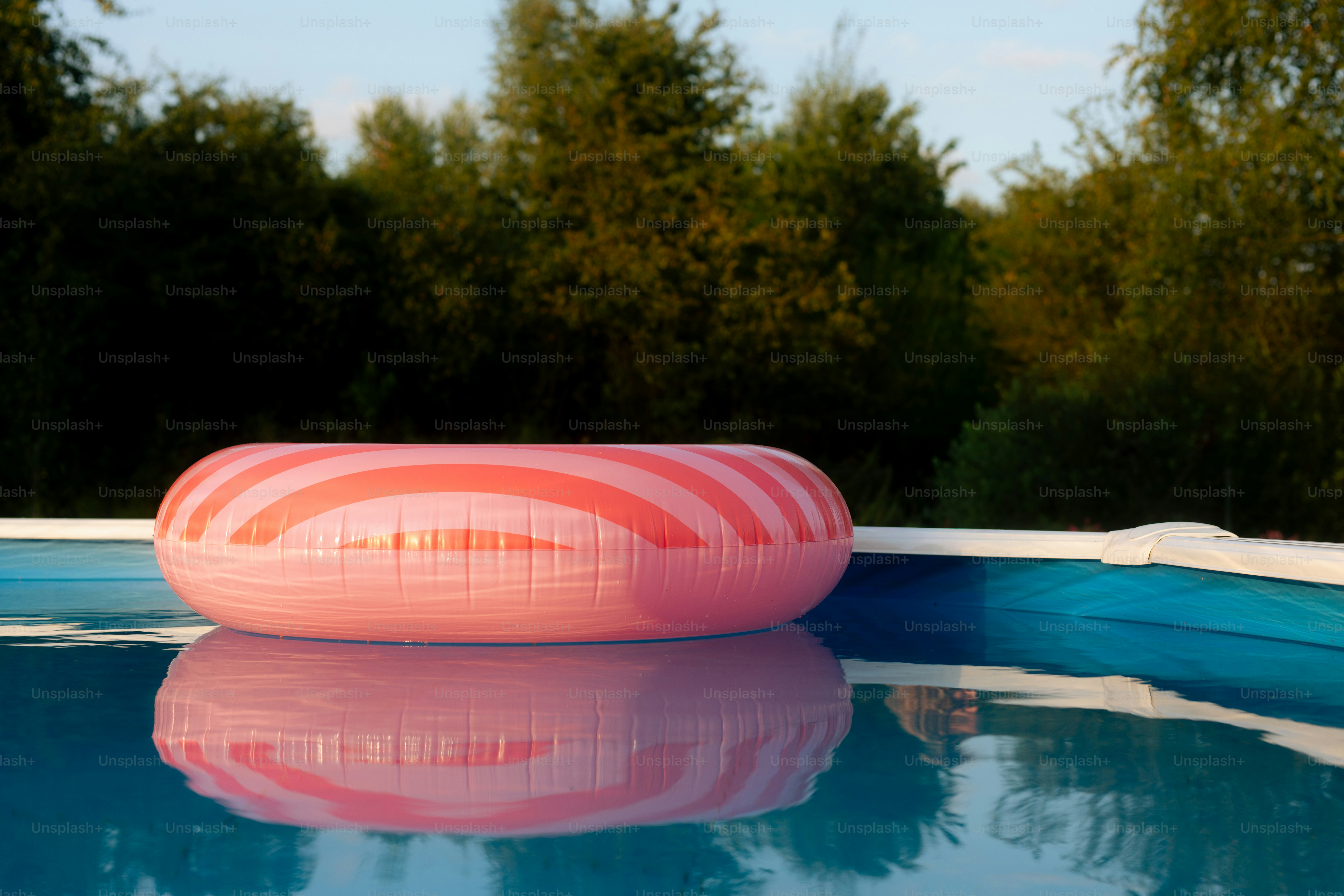Pink inflatable ring floating in a swimming pool photo – Image on Unsplash
