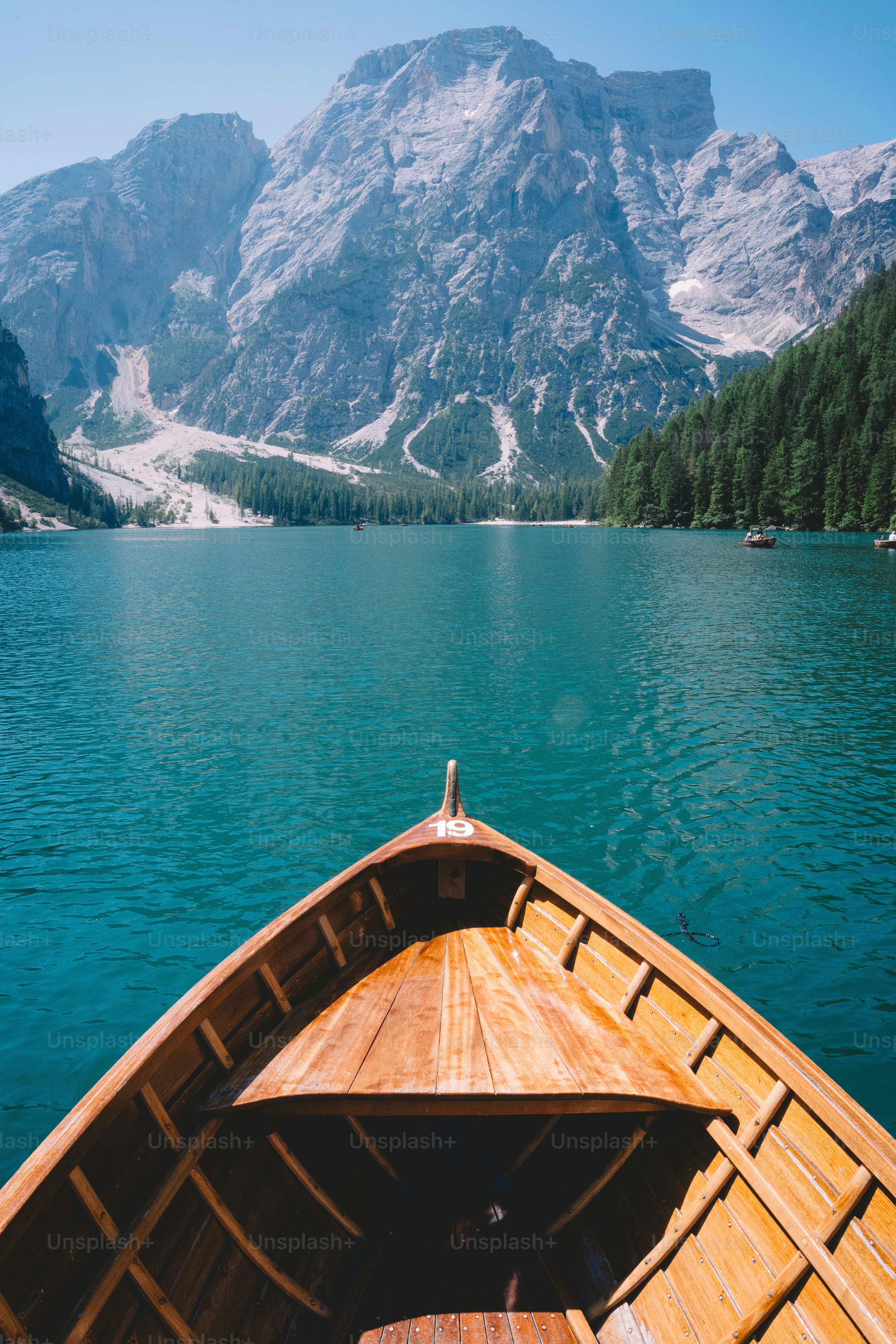 Wooden boat on a vibrant blue lake with mountains. photo – Forest Image ...
