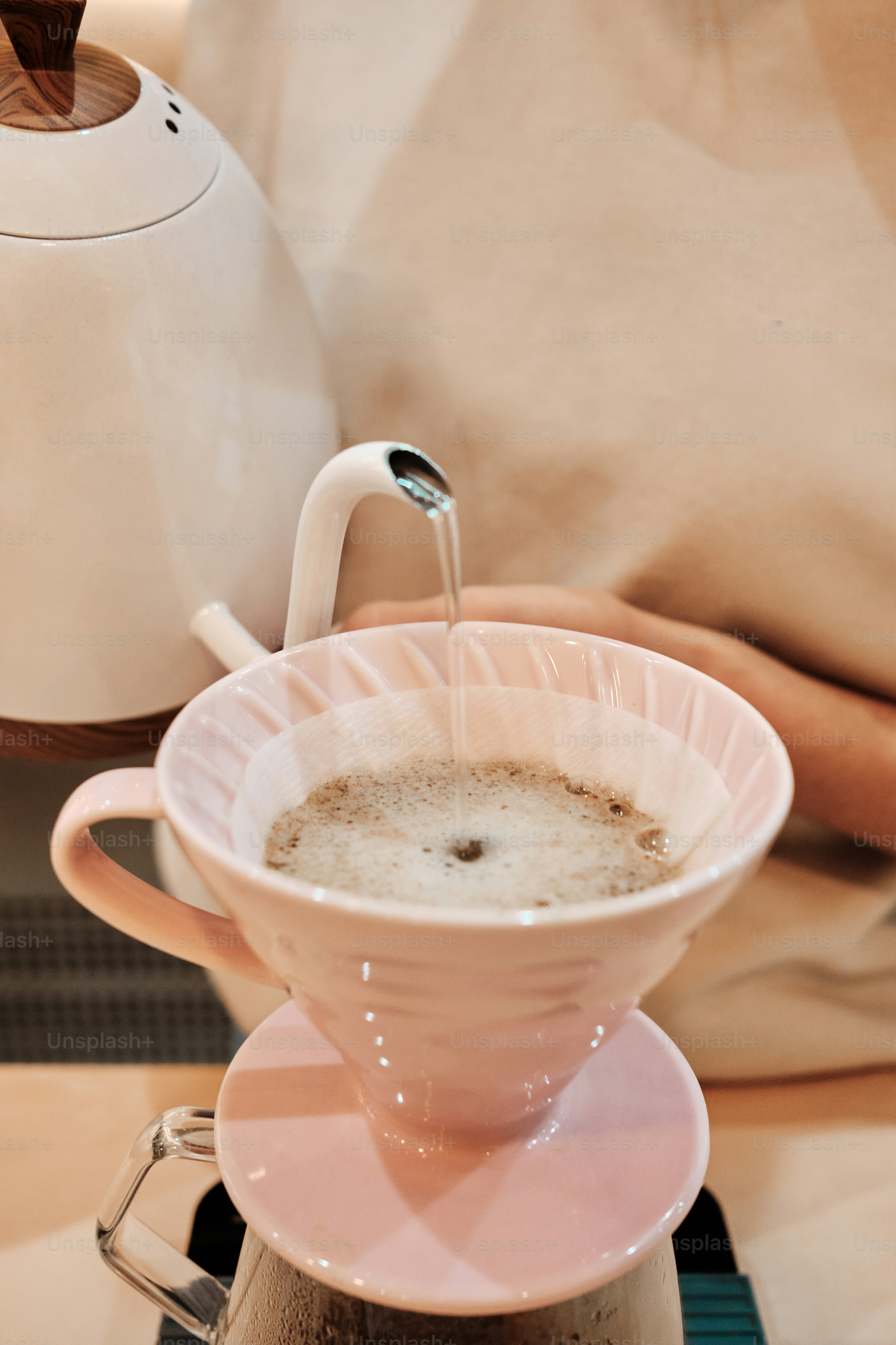 Pouring hot water over coffee grounds in a pink dripper. photo – Coffee ...