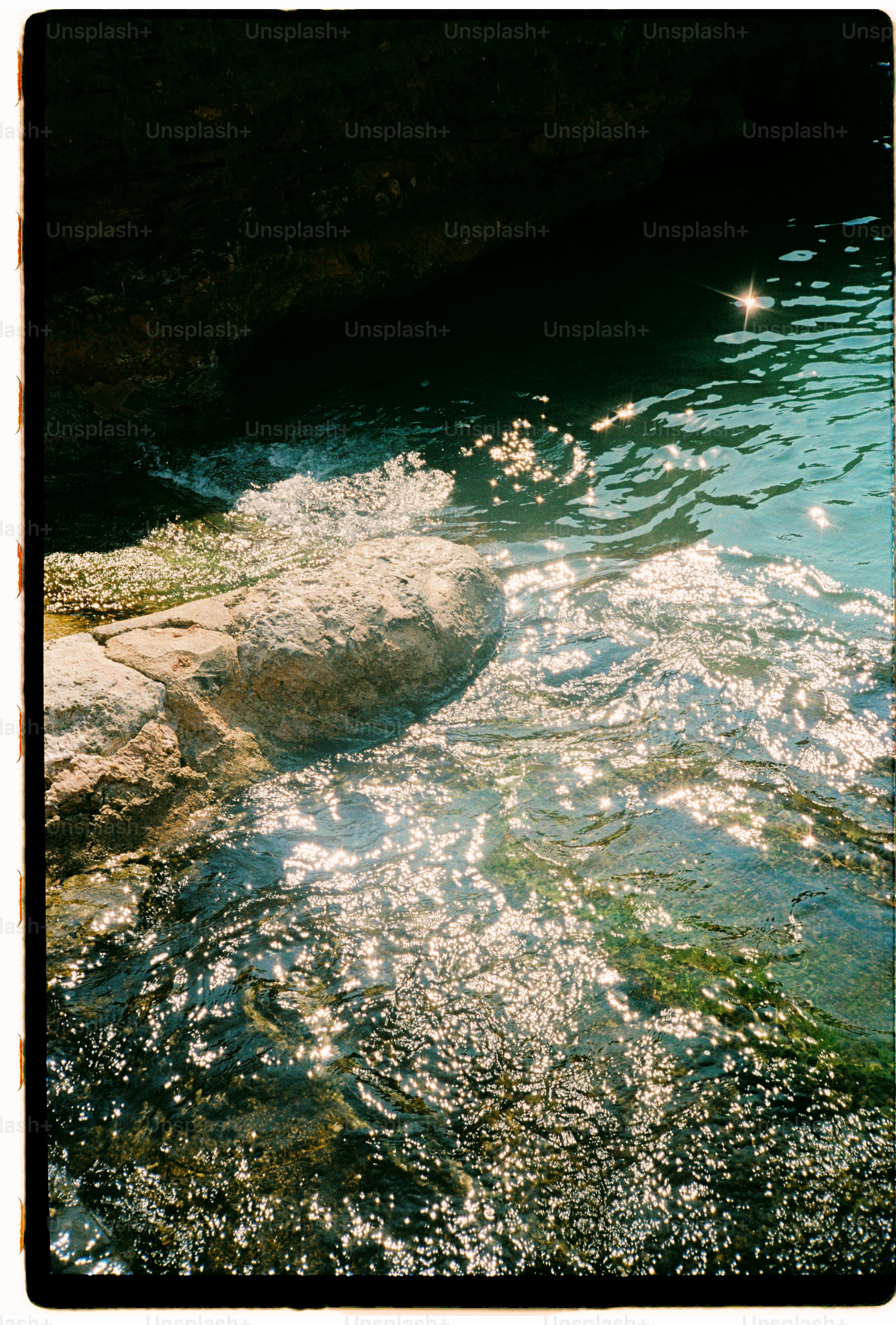 Sunlight sparkles on rippling water near rocks. photo – Outdoor Image ...