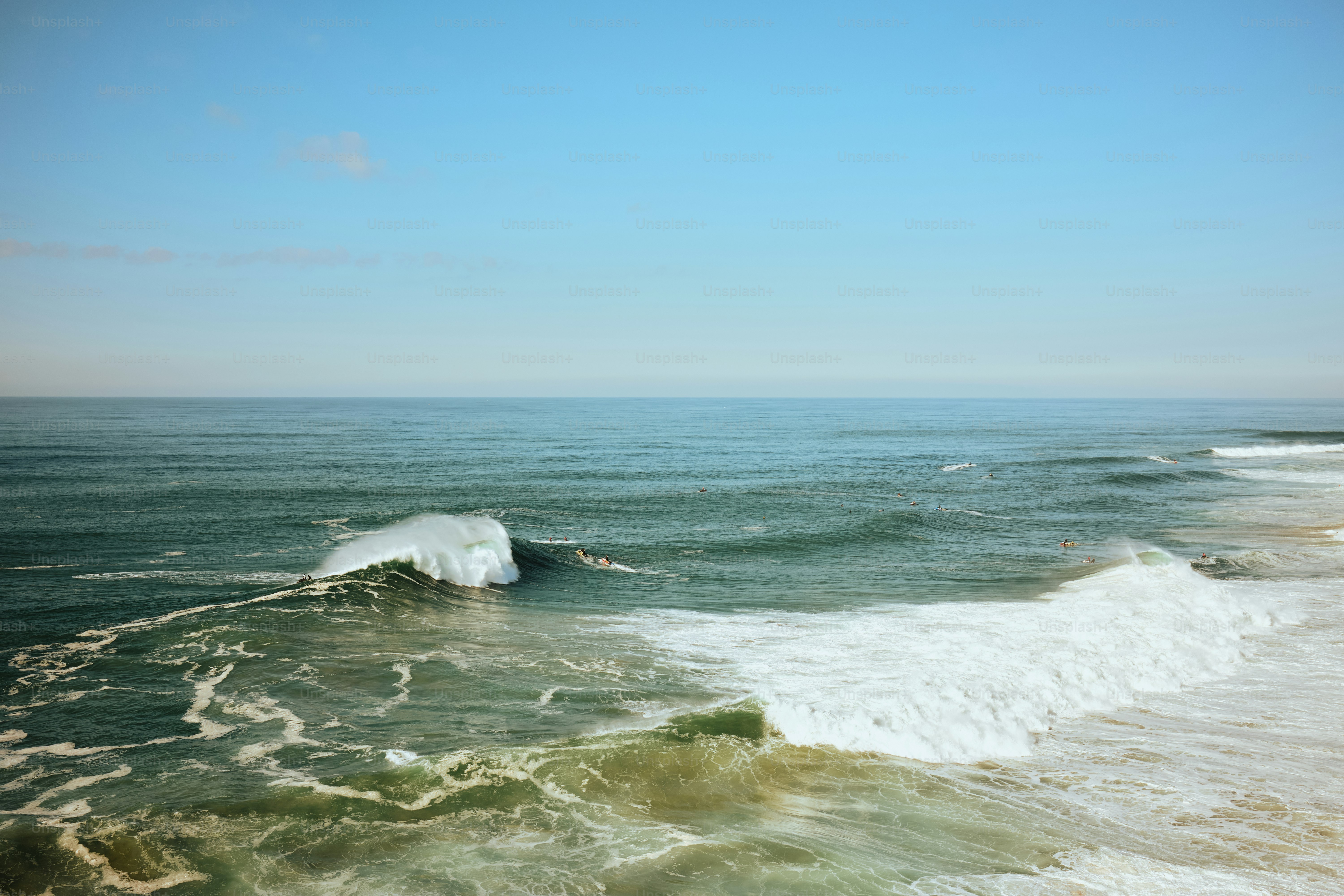 Olas rompiendo en una playa de arena bajo un cielo despejado foto ...
