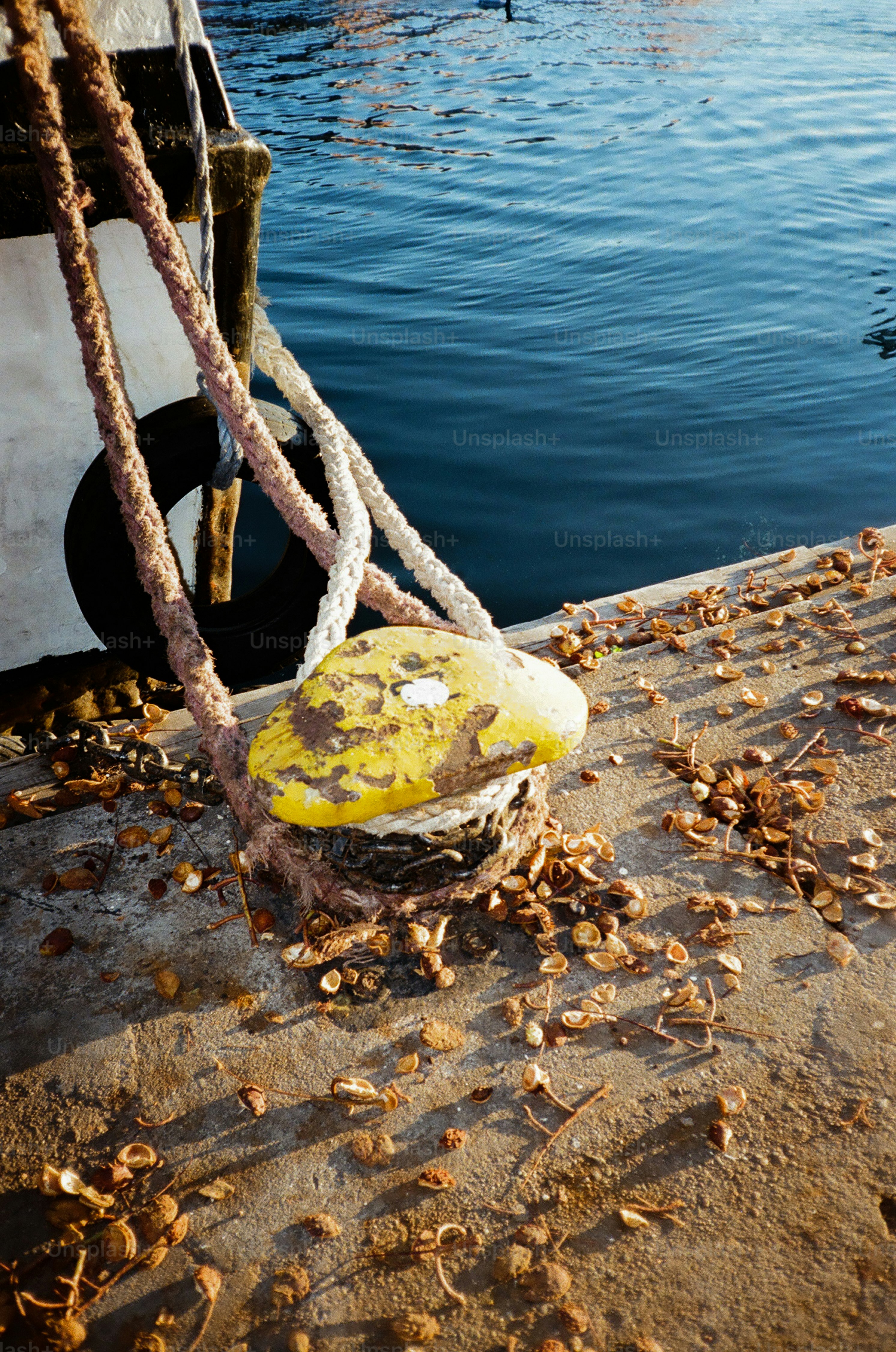 Barco atracado a um cais com cordas e destroços foto – Imagem sobre ...