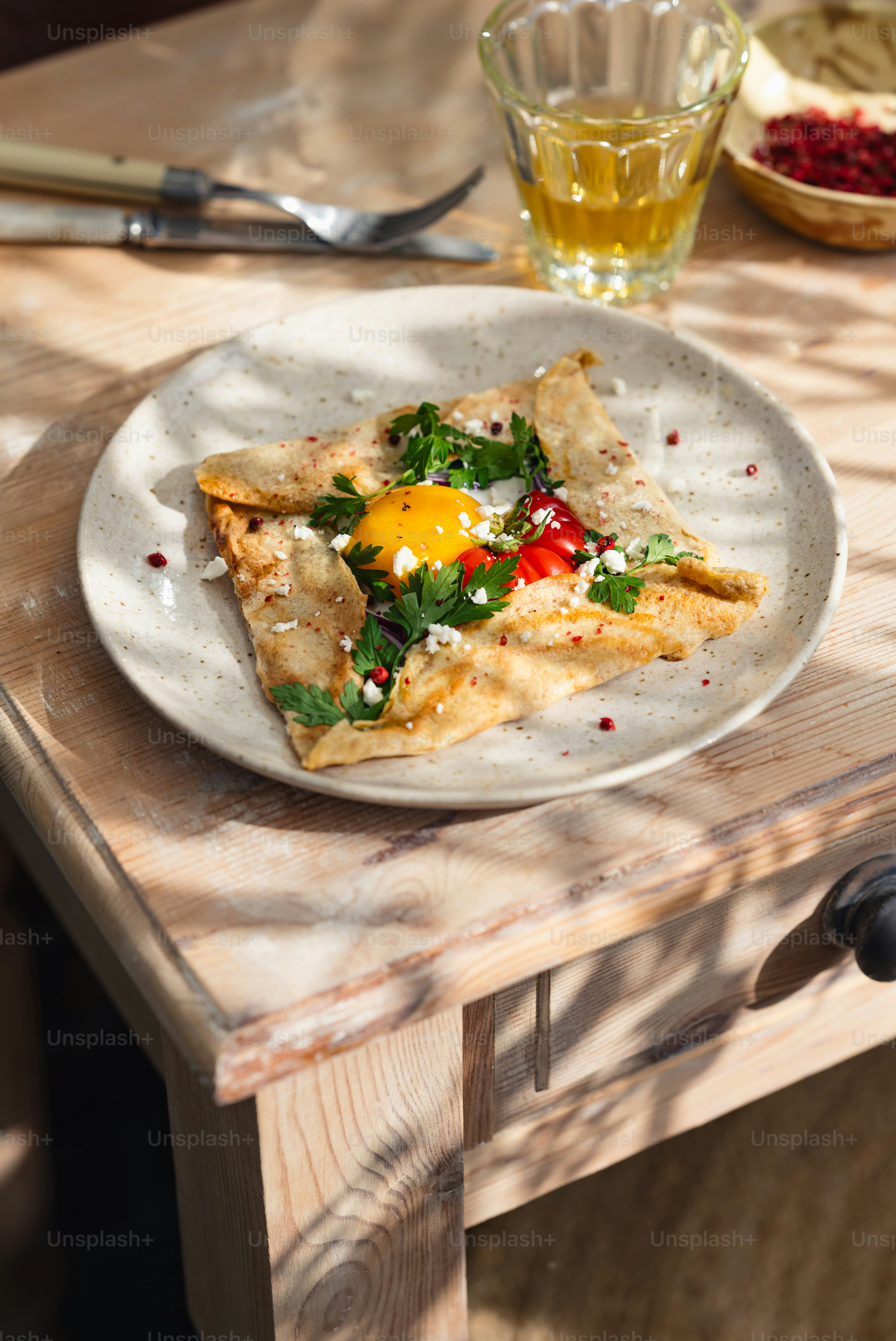 Savory crepe with egg, cheese, and herbs on plate. photo – Food Image ...