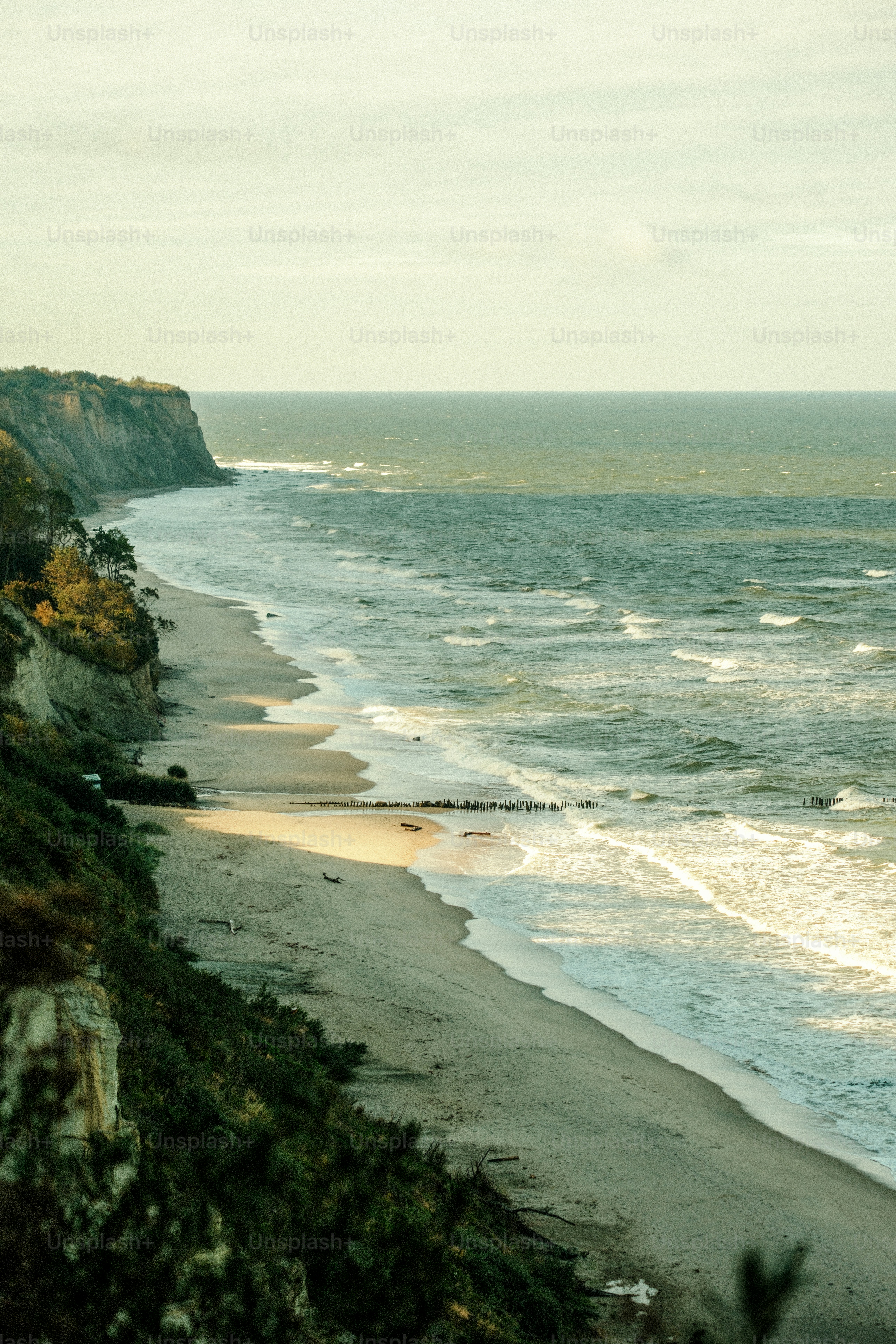 Coastal cliffs overlooking a sandy beach and ocean waves photo – Beach ...