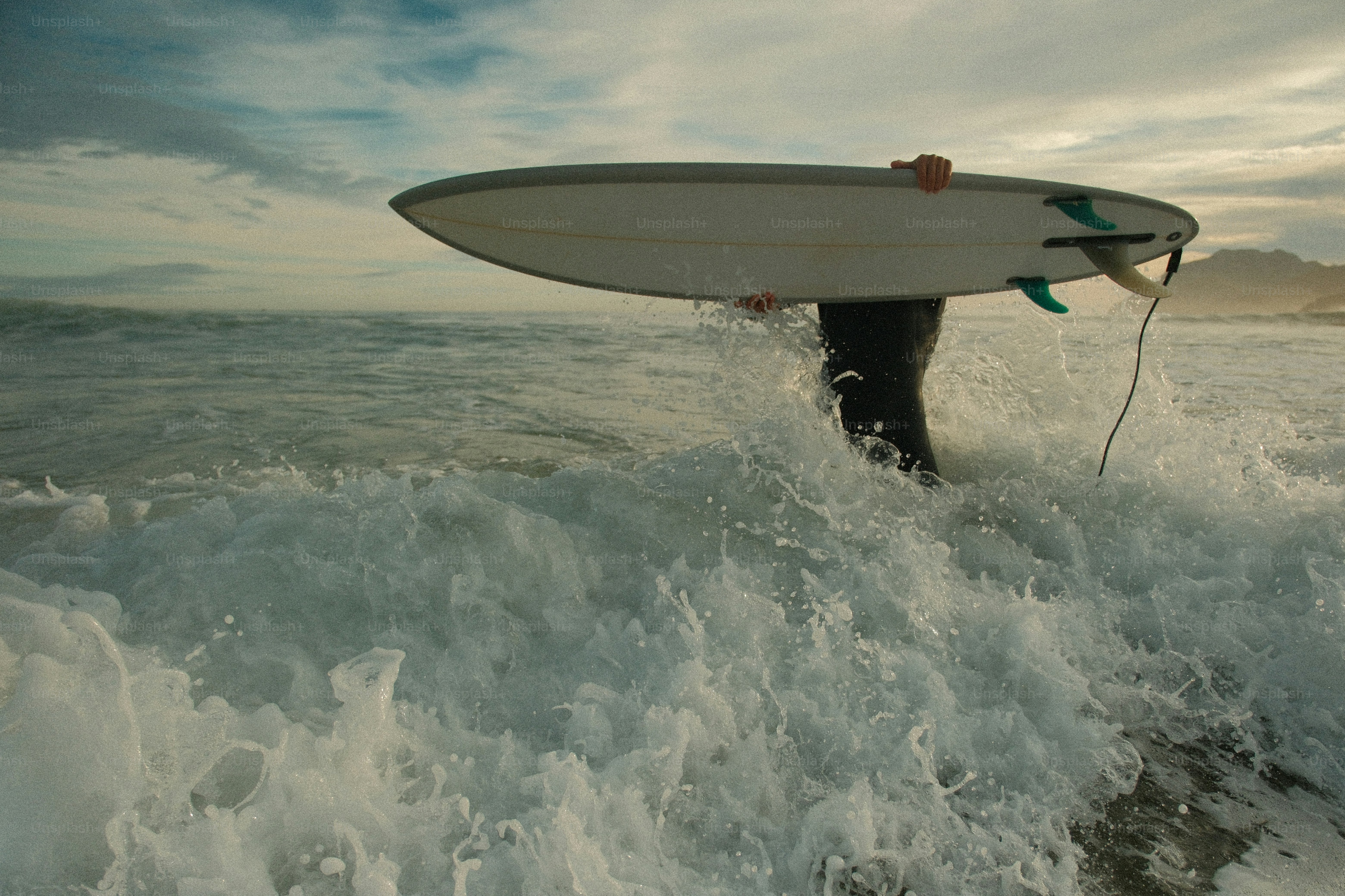 Surfer carrying surfboard through ocean waves photo – Beach Image on ...