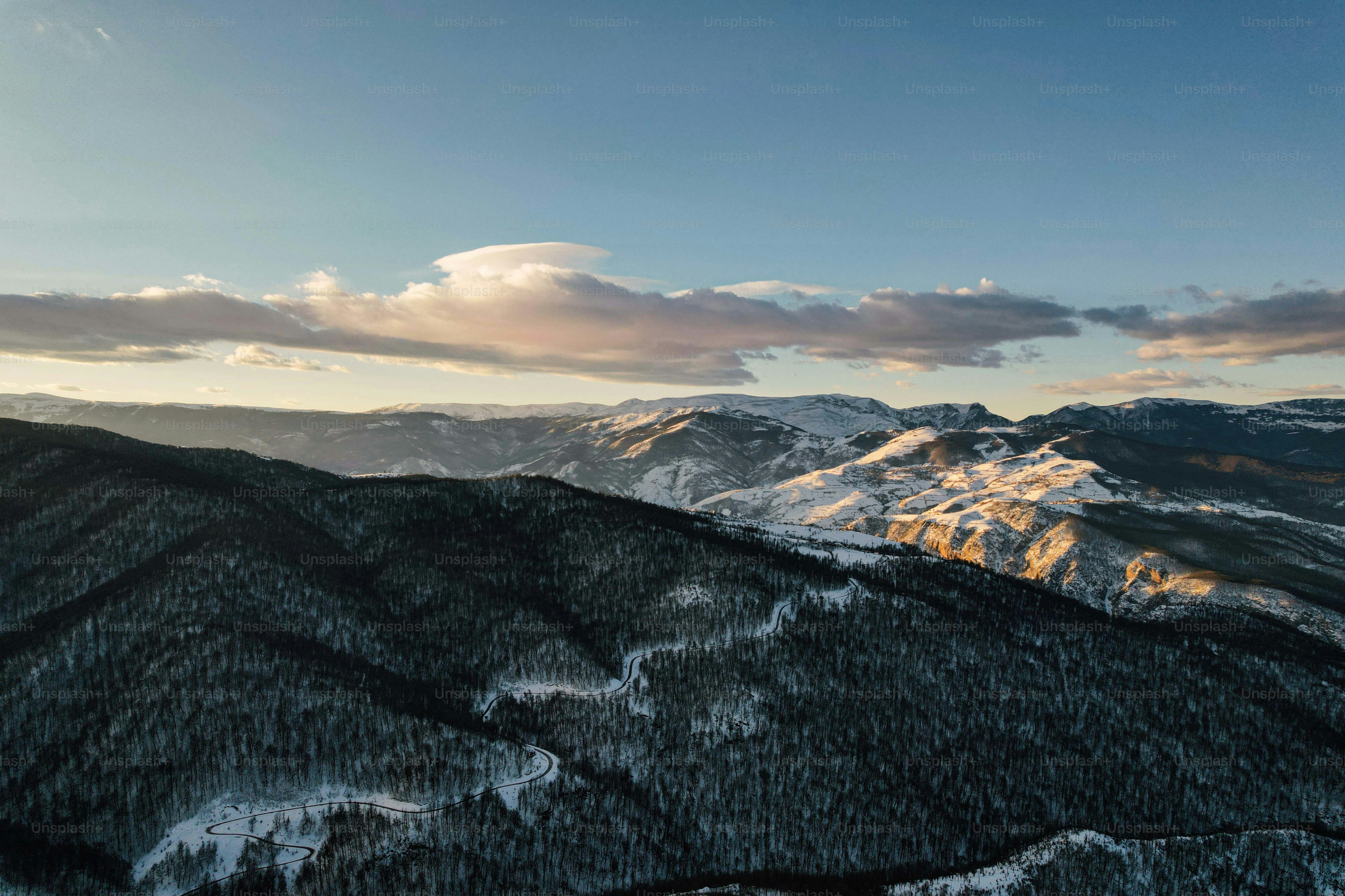 Snow-covered mountains under a cloudy sky at dawn. photo – Mountains ...