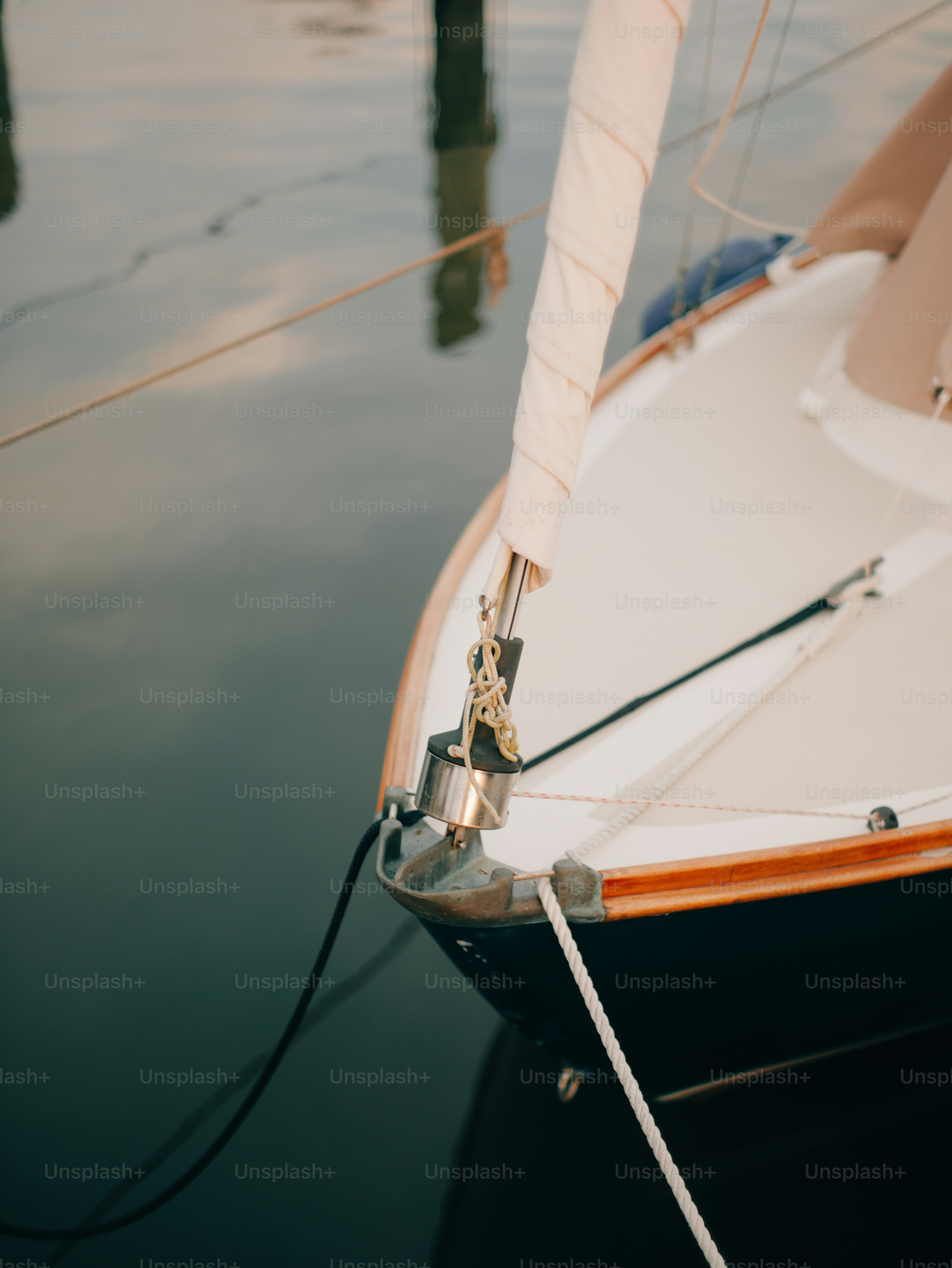 Close-up of a sailboat docked in calm water. photo – Image on Unsplash
