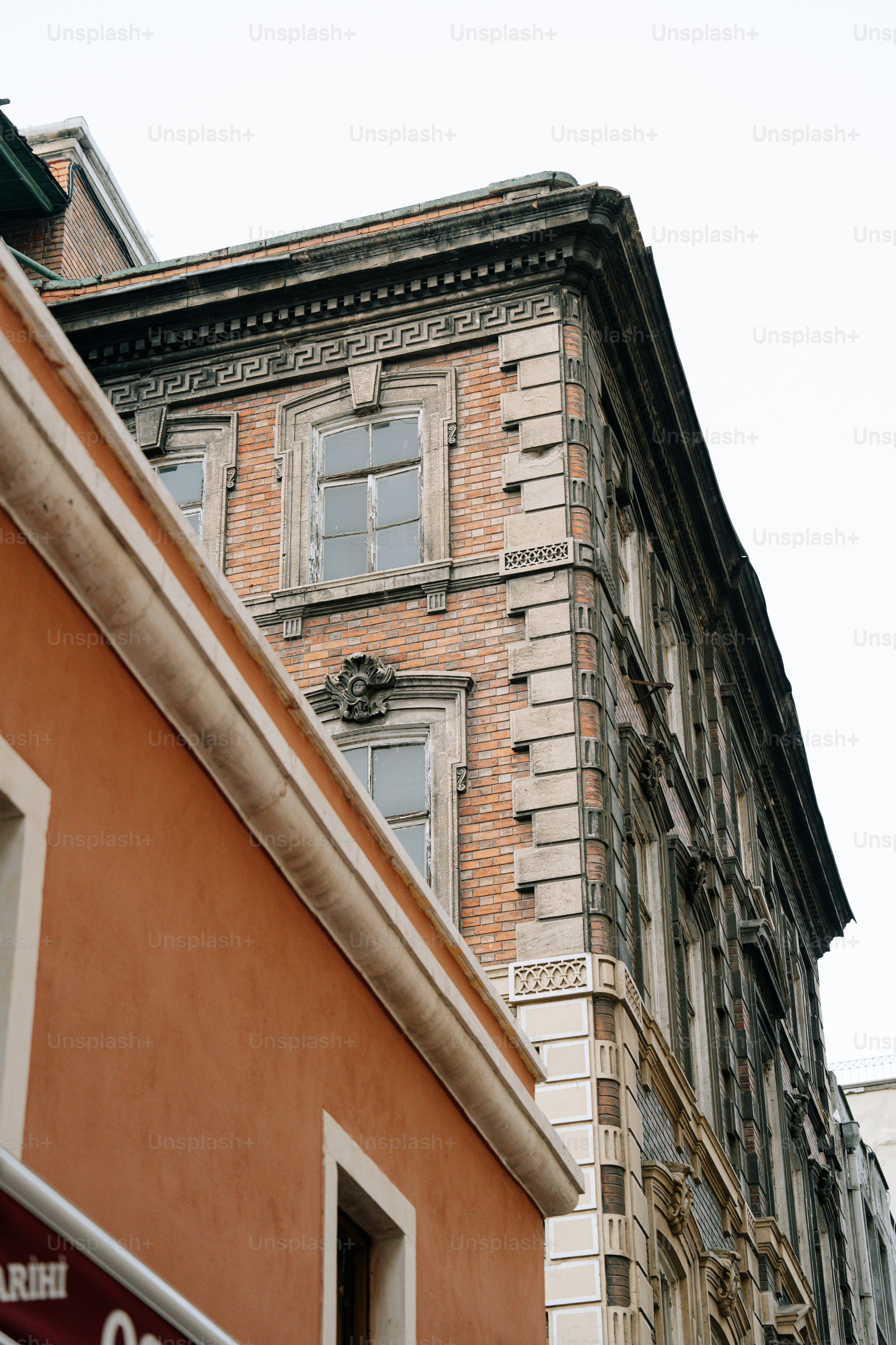 Corner of old brick building with ornate stonework photo – Cityscape ...
