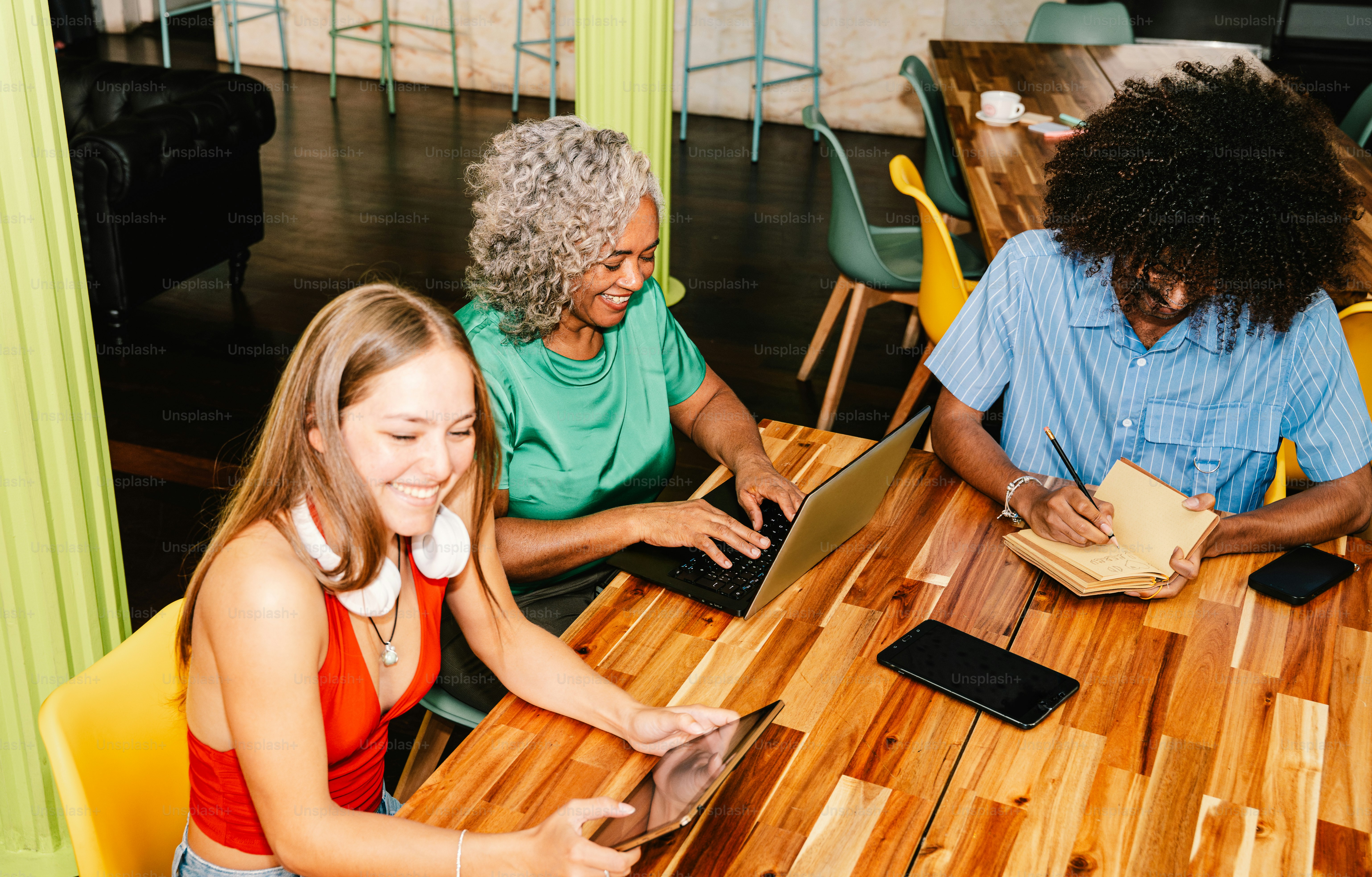 Three people working together at a wooden table. photo – Team Image on ...