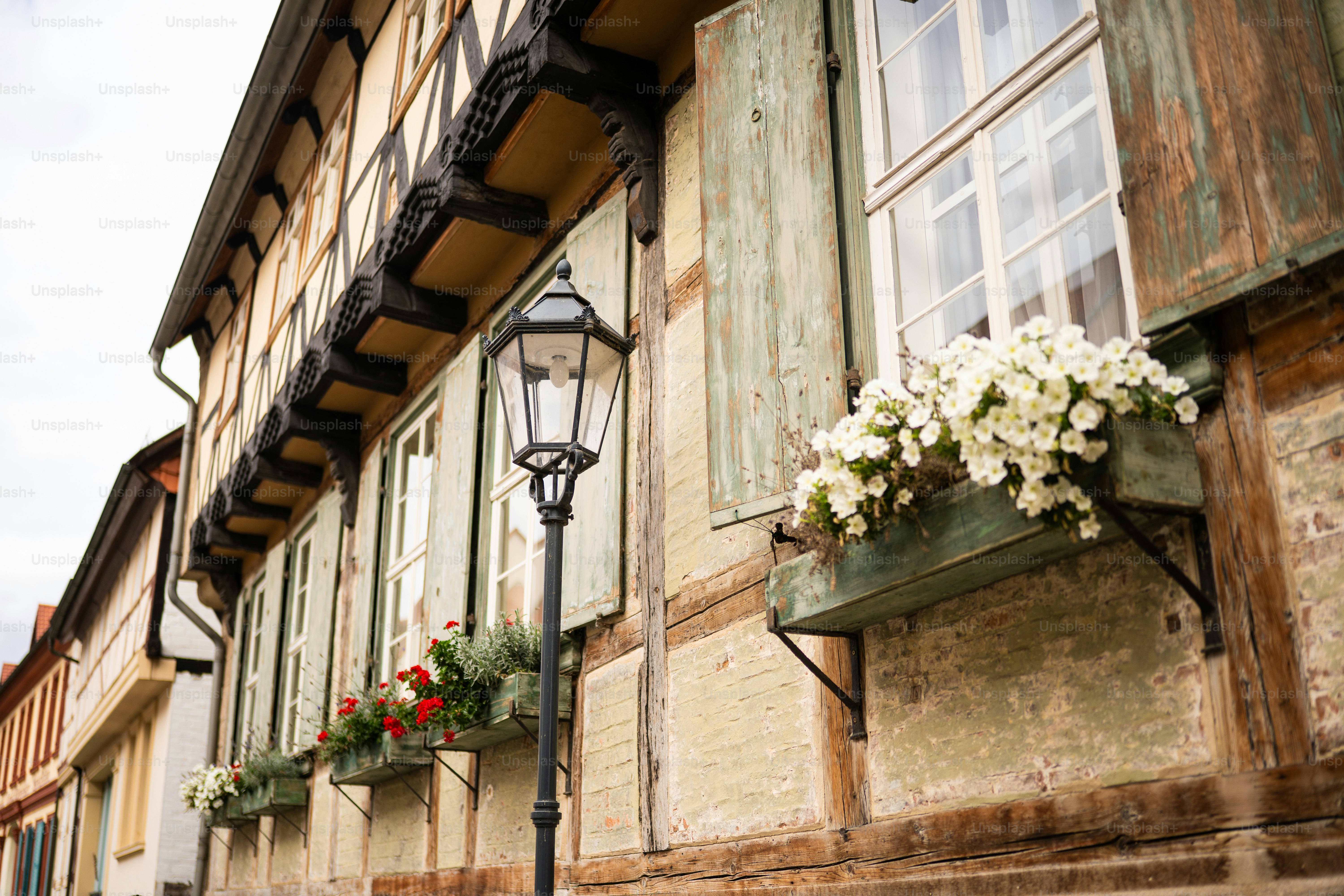 Historic building facade with flower boxes and lamp. photo ...