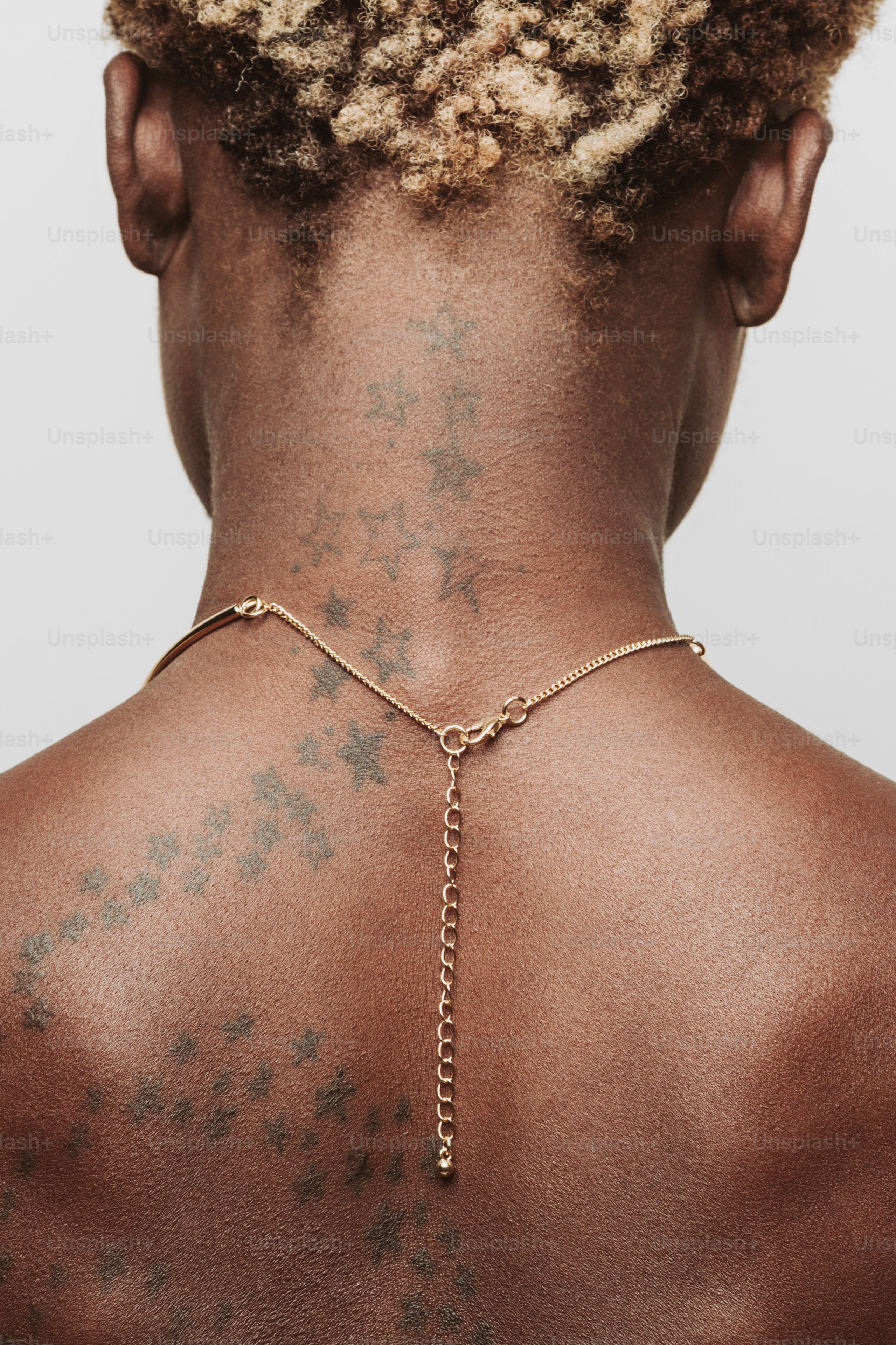 Back view of person with star tattoos and necklace photo – Woman Image ...